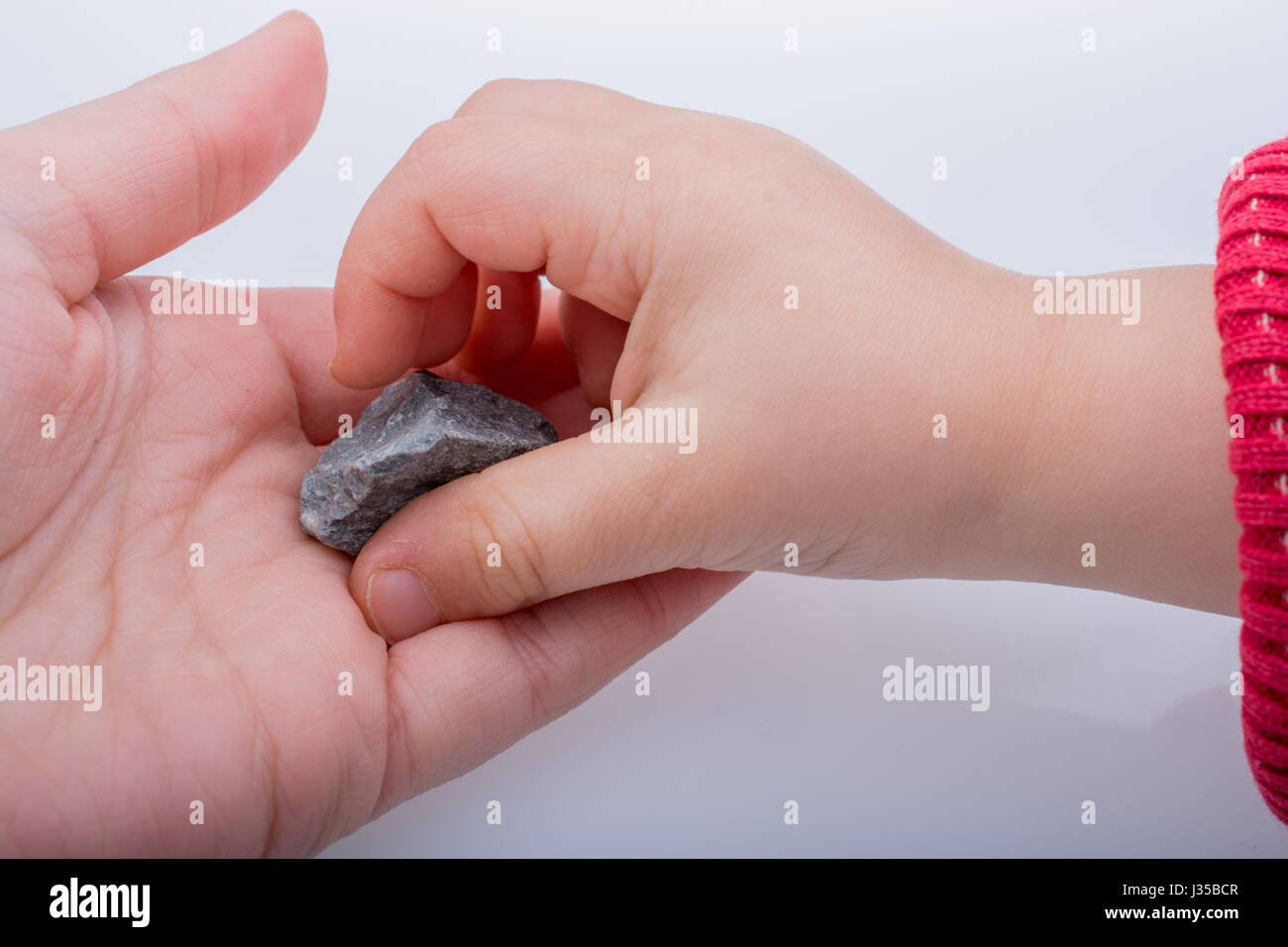Hand holding a little stone in hand Stock Photo - Alamy