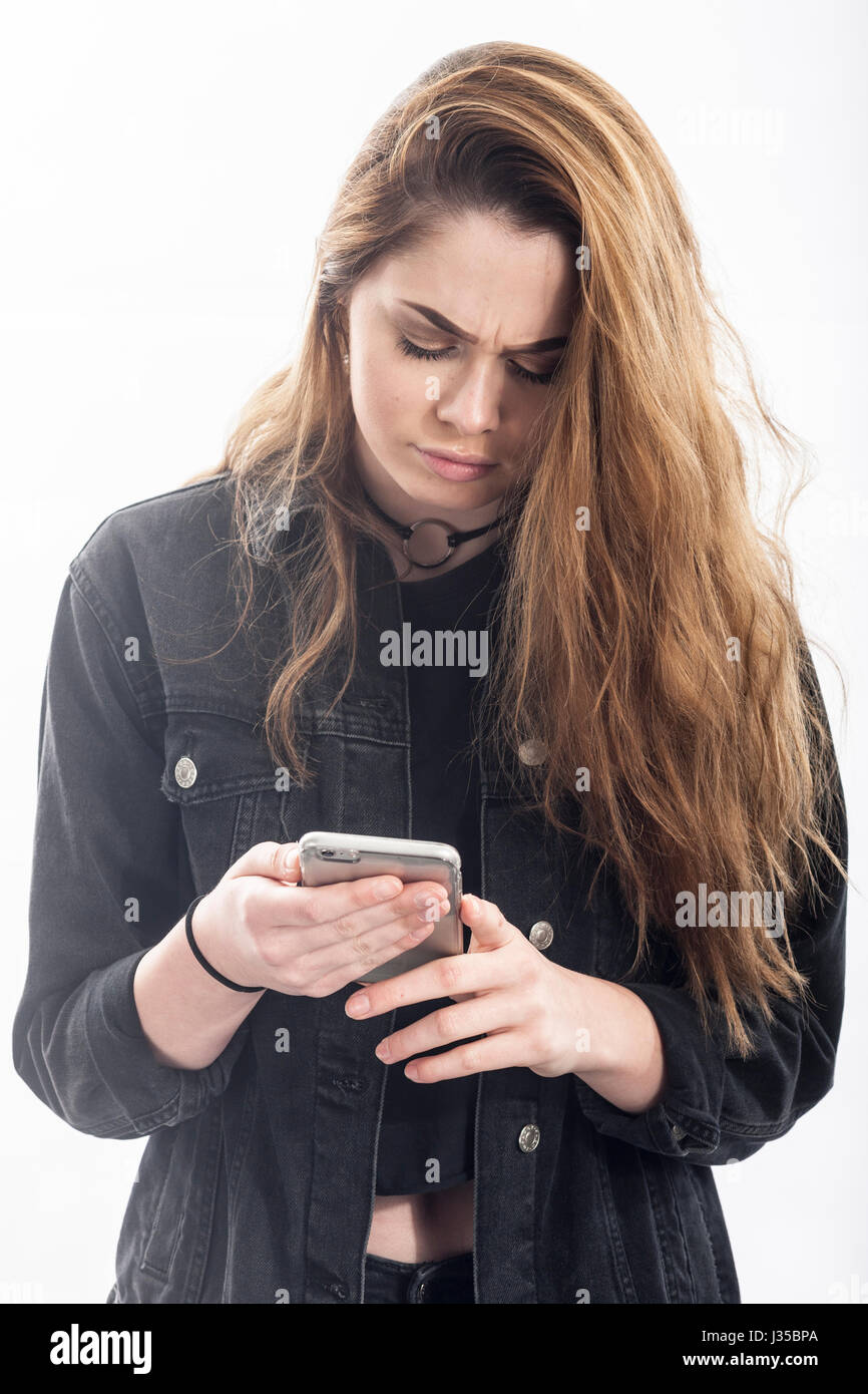 A pretty 15 year old girl texting / messaging on smartphone in the ...