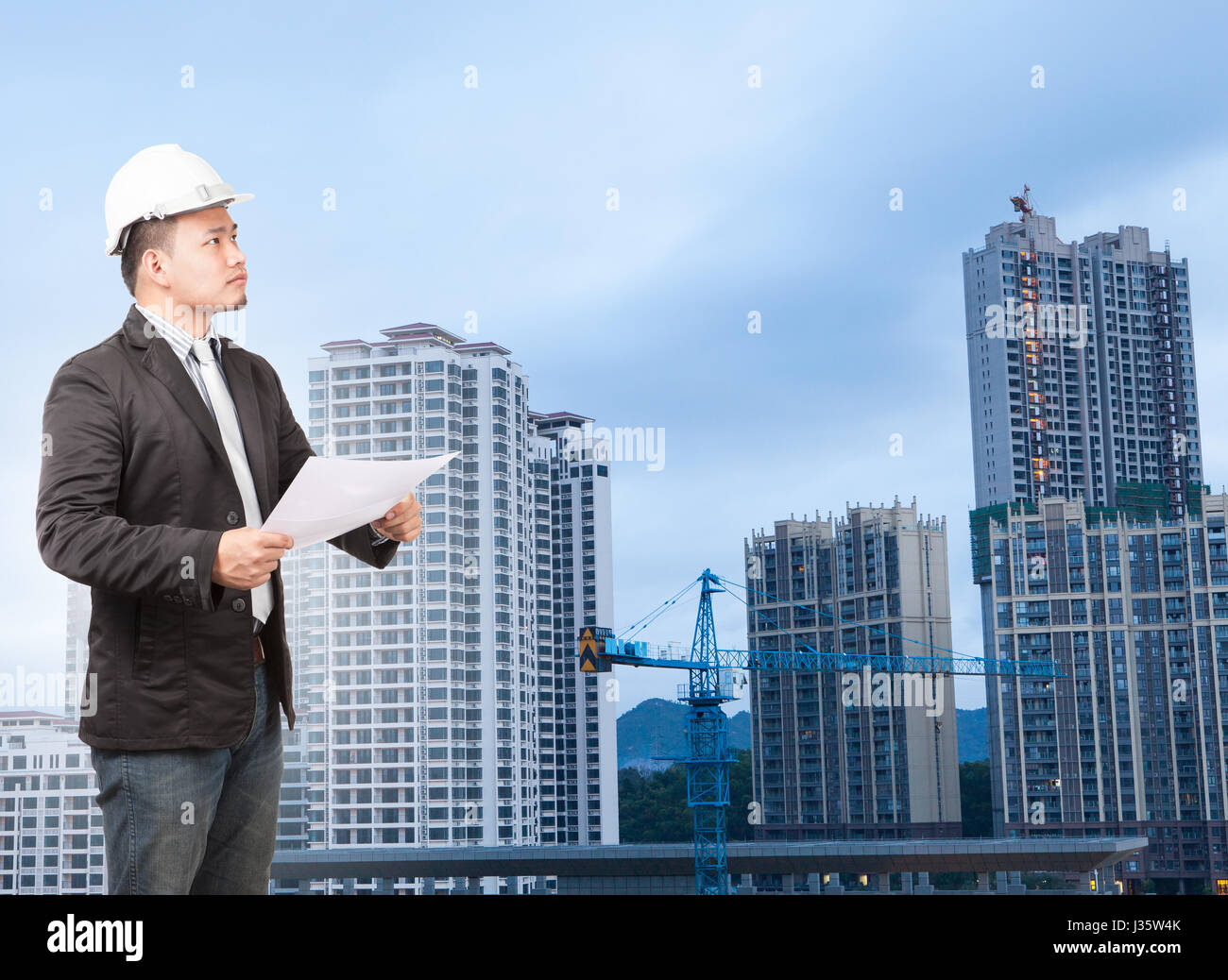 engineering man wearing western suit and safety helmet with building ...