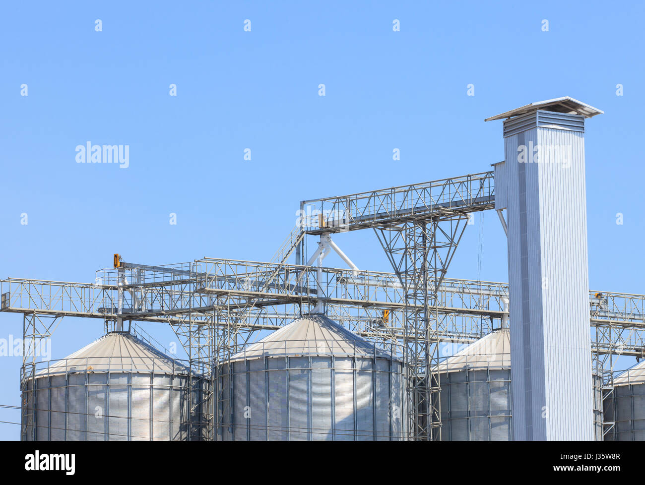 exterior structure of new agriculture silo building against blue sky ...
