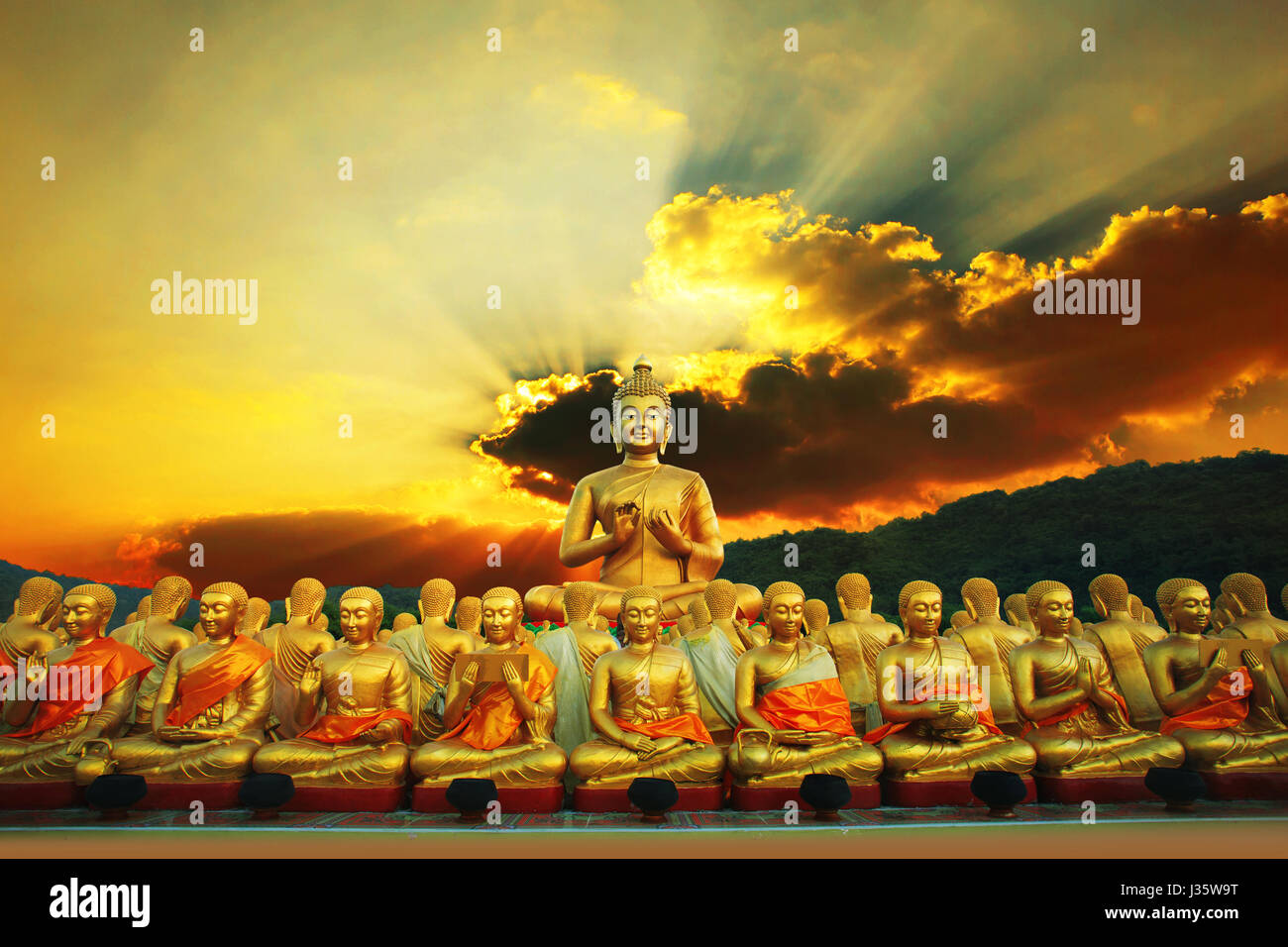 golden buddha statue in buddhism temple thailand against dramatic sun ...