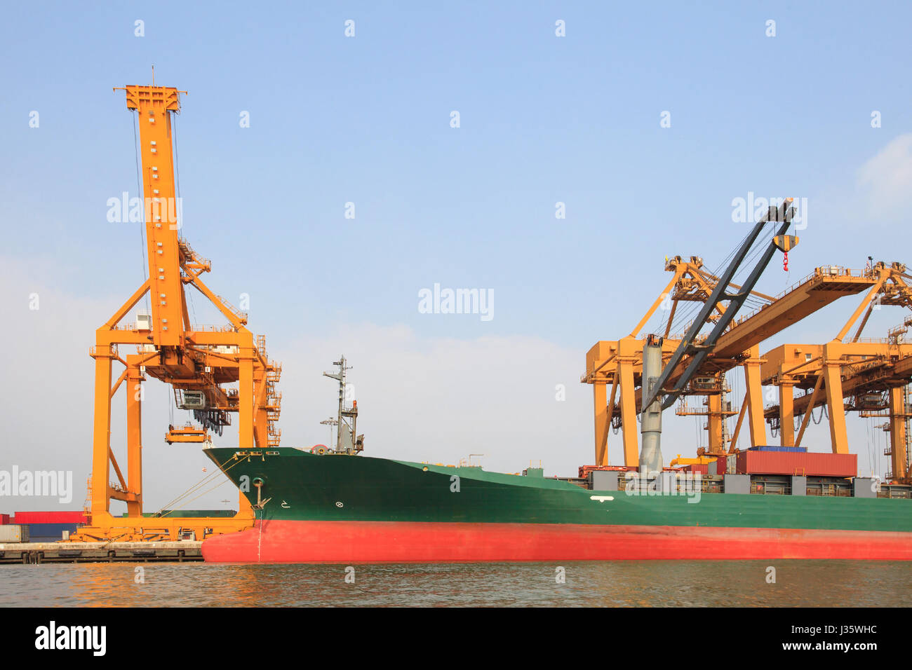 commercial ship on port with big loading crane Stock Photo - Alamy