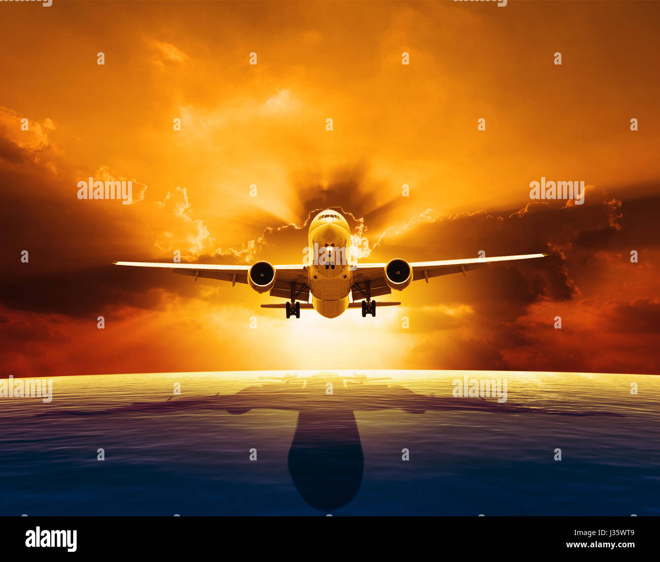 passenger jet plane flying over beautiful sea level with sun set sky ...