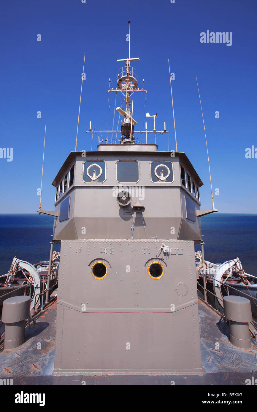 front view of military ship bridge control room against clear blue sea ...