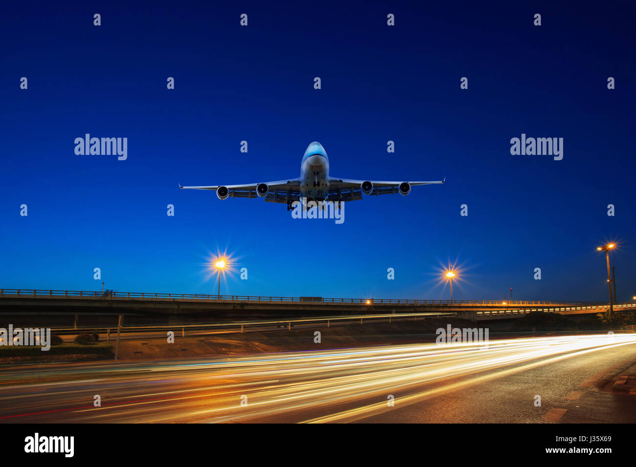 flying passenger jet plane above traffic light on express ways use as ...