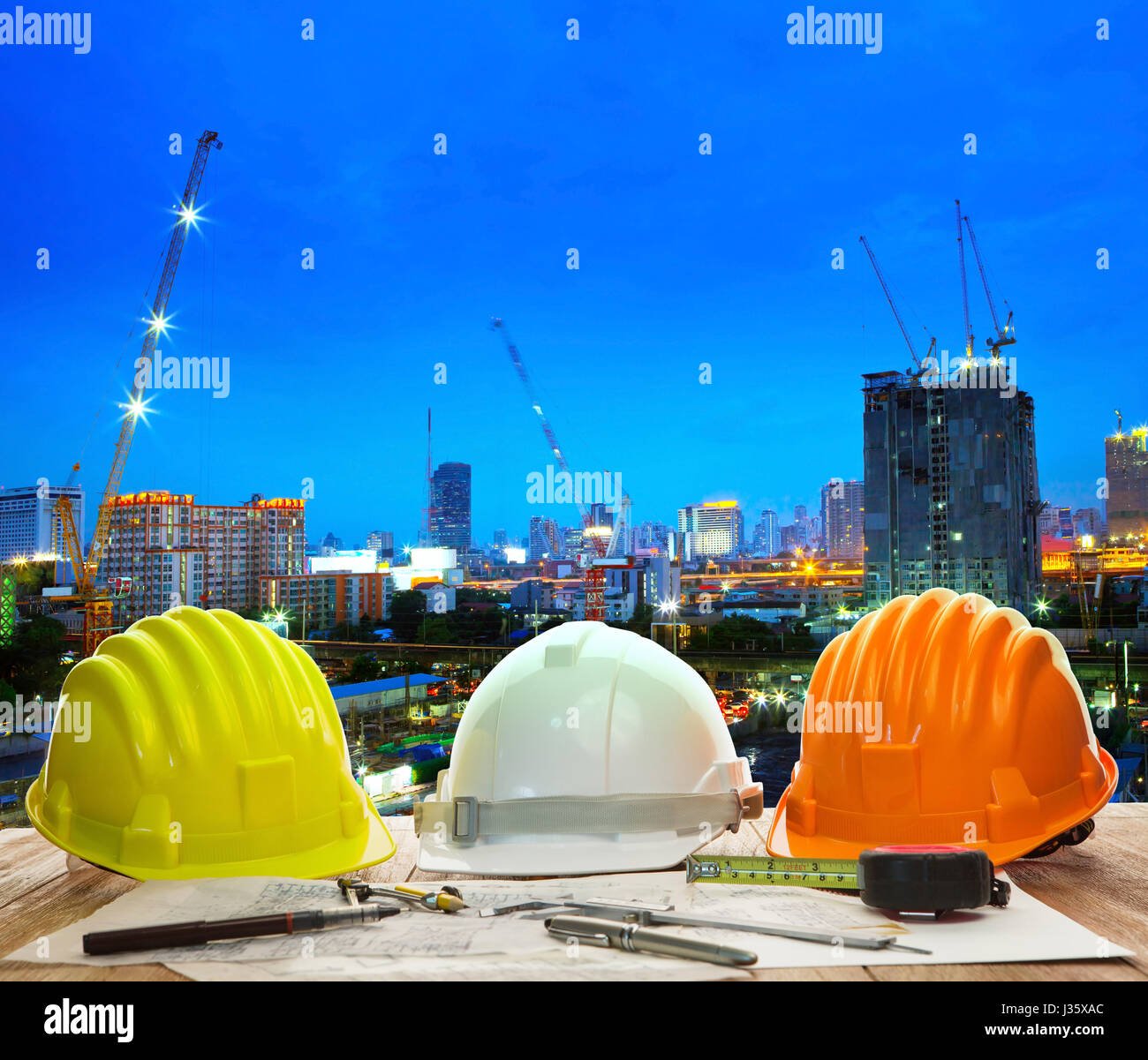 engineer working table with hard hat plan and writing tool against ...
