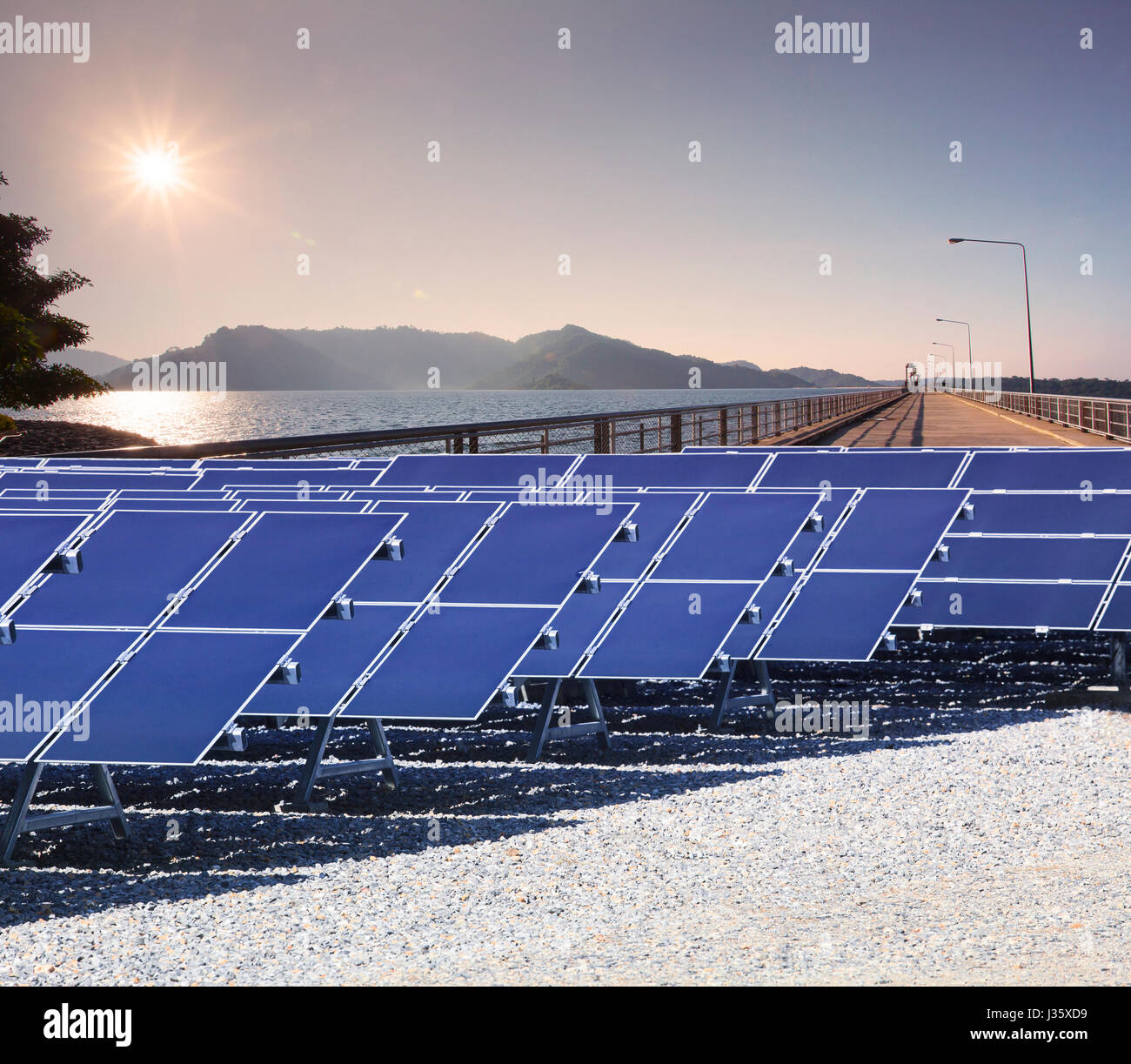 sun shining over sky and lake of generator electric dam with solar cell ...