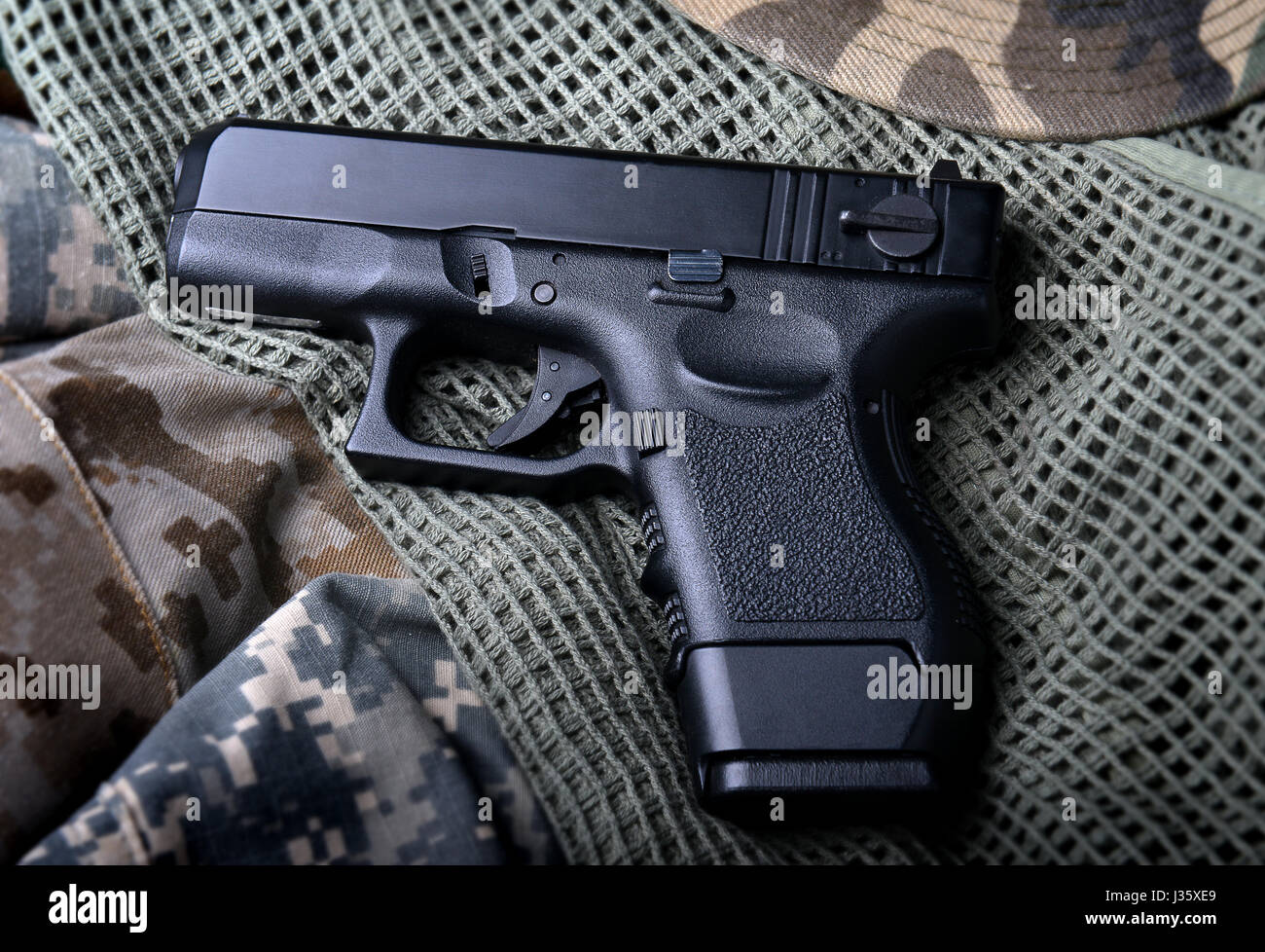 Pistal automatic short hand gun in the US army prop background photo in lowlighting and dark ...