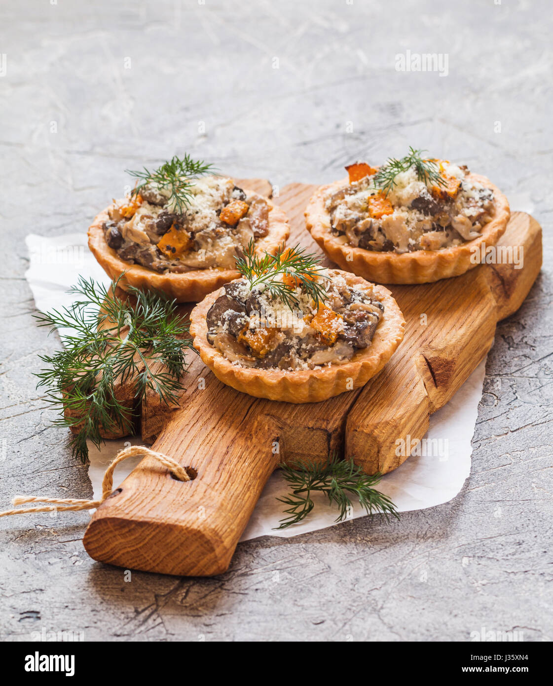 Homemade savory autumn tarts with fresh seasonal mushrooms in a crisp ...