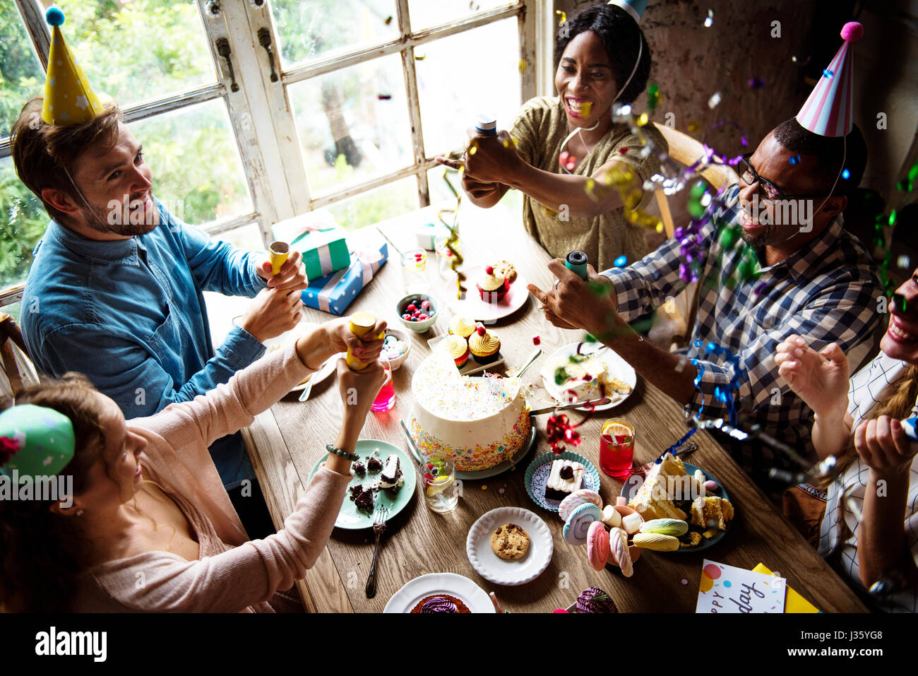 People Using Party Popping on Friend Birthday Celebration Stock Photo ...