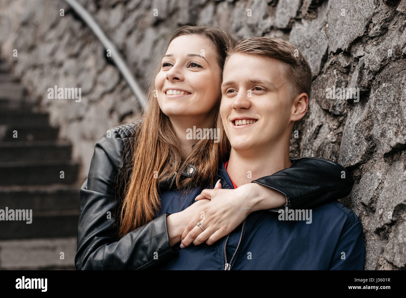A young happy student couple in embrace looking into distance Stock ...