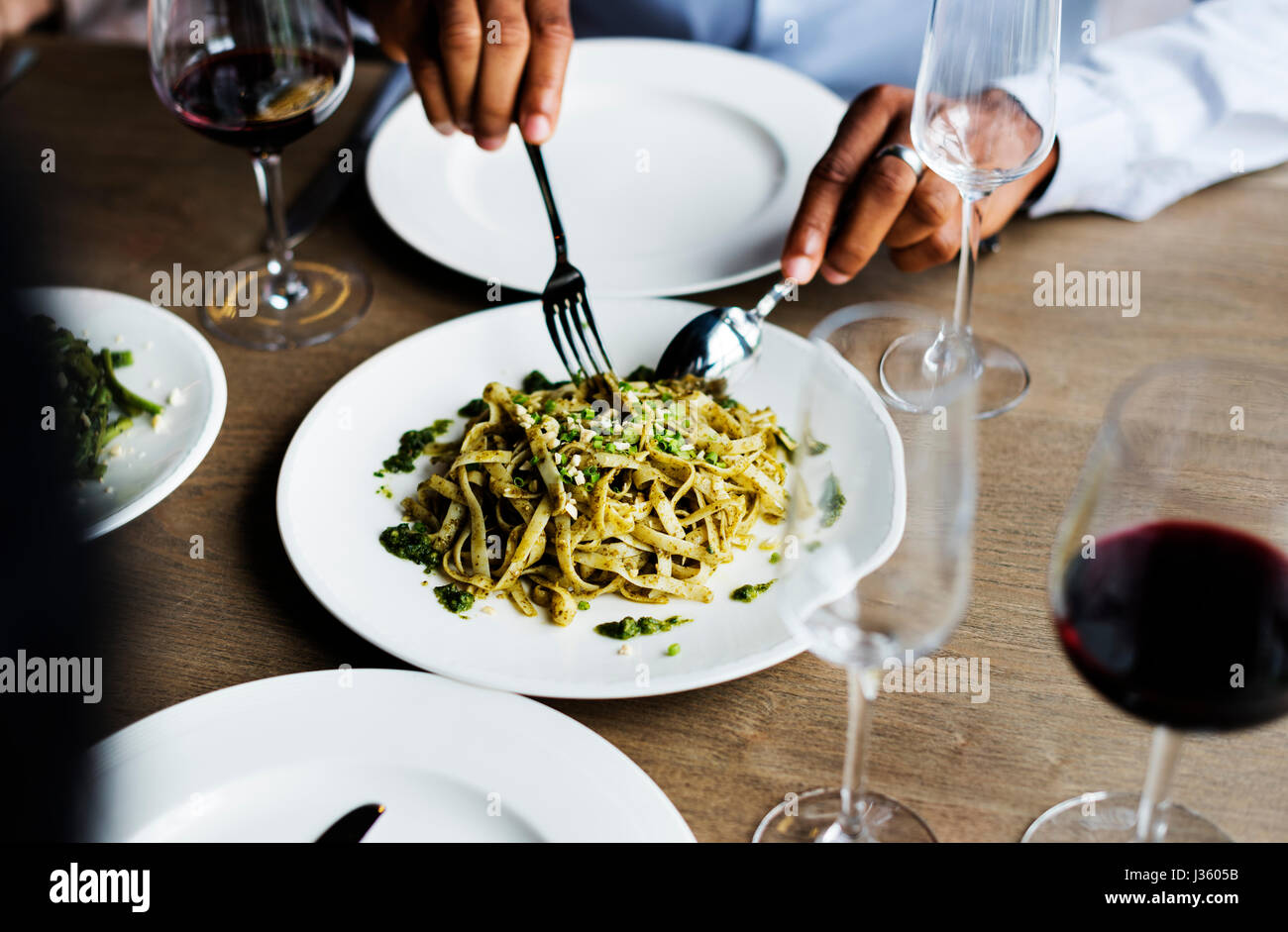 Hands Holding Knife and Fork Getting Food From Dish Stock Photo - Alamy