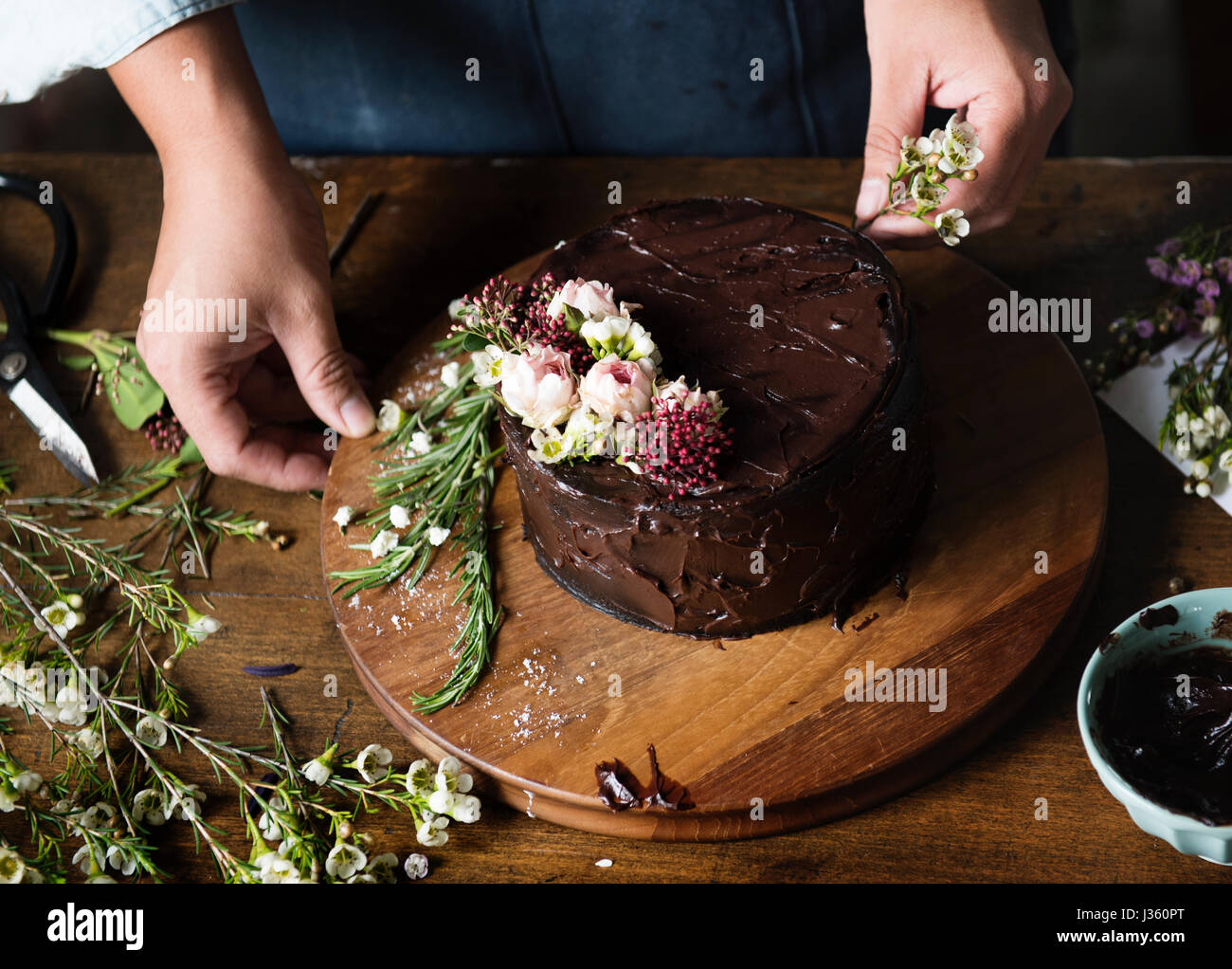 Baker Man Decorating Chocolate Cake with Flowers Stock Photo - Alamy