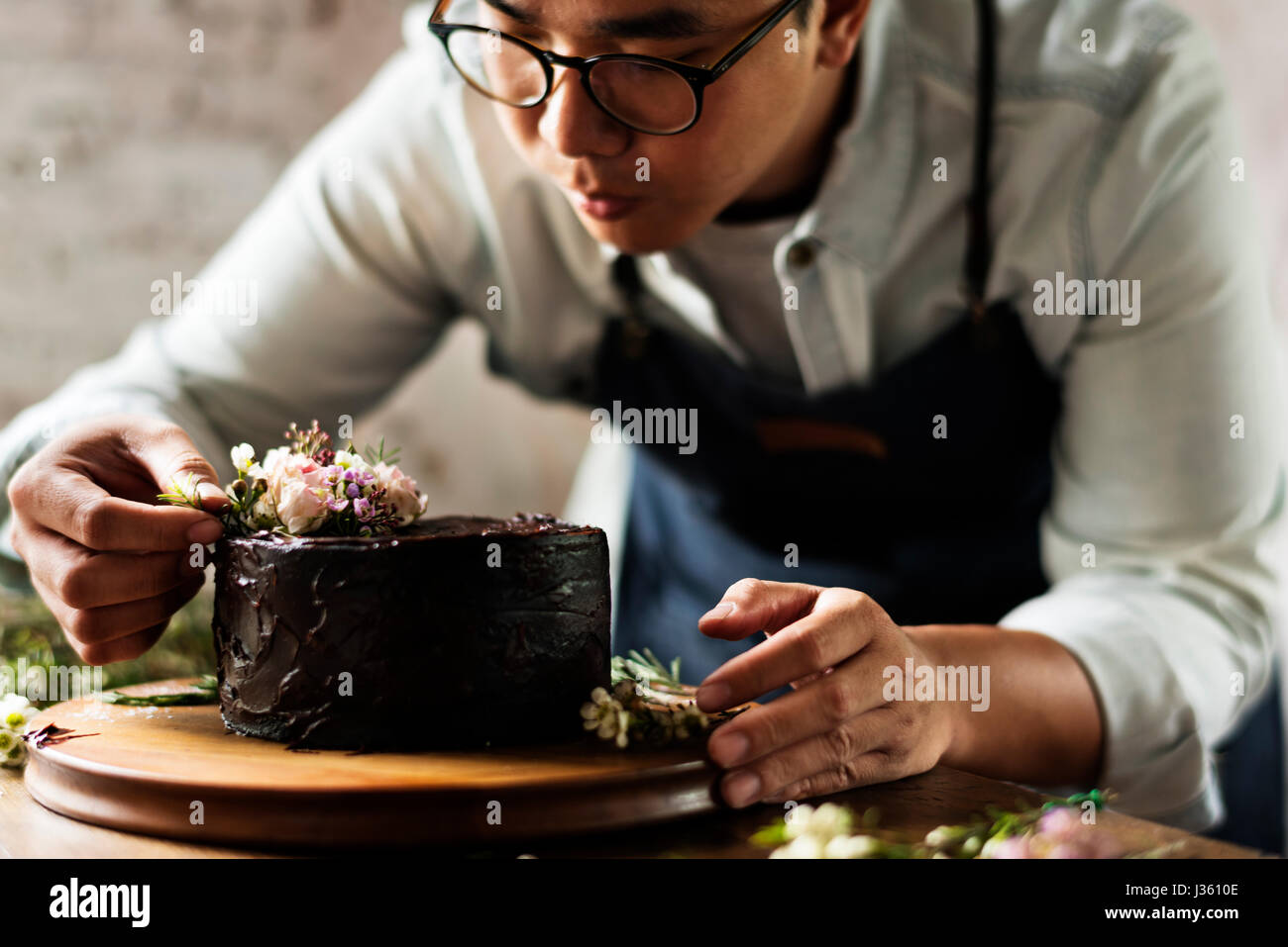 Baker Man Decorating Chocolate Cake with Flowers Stock Photo - Alamy