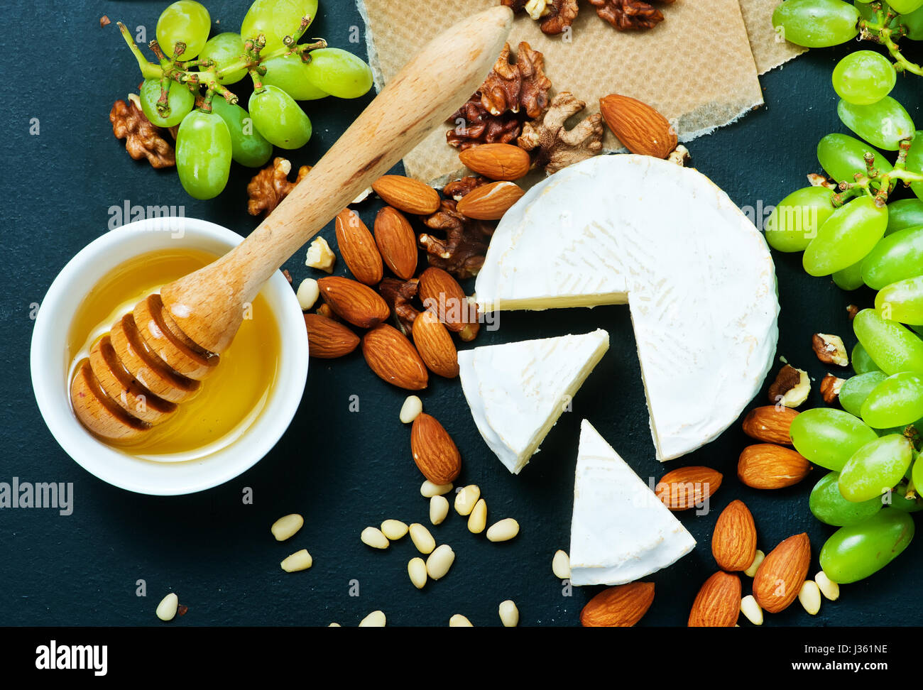 cheese with honey and nuts on a table Stock Photo - Alamy