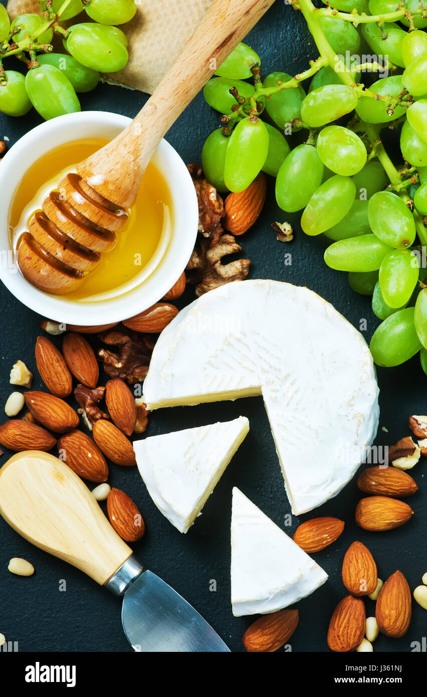 cheese with honey and nuts on a table Stock Photo - Alamy