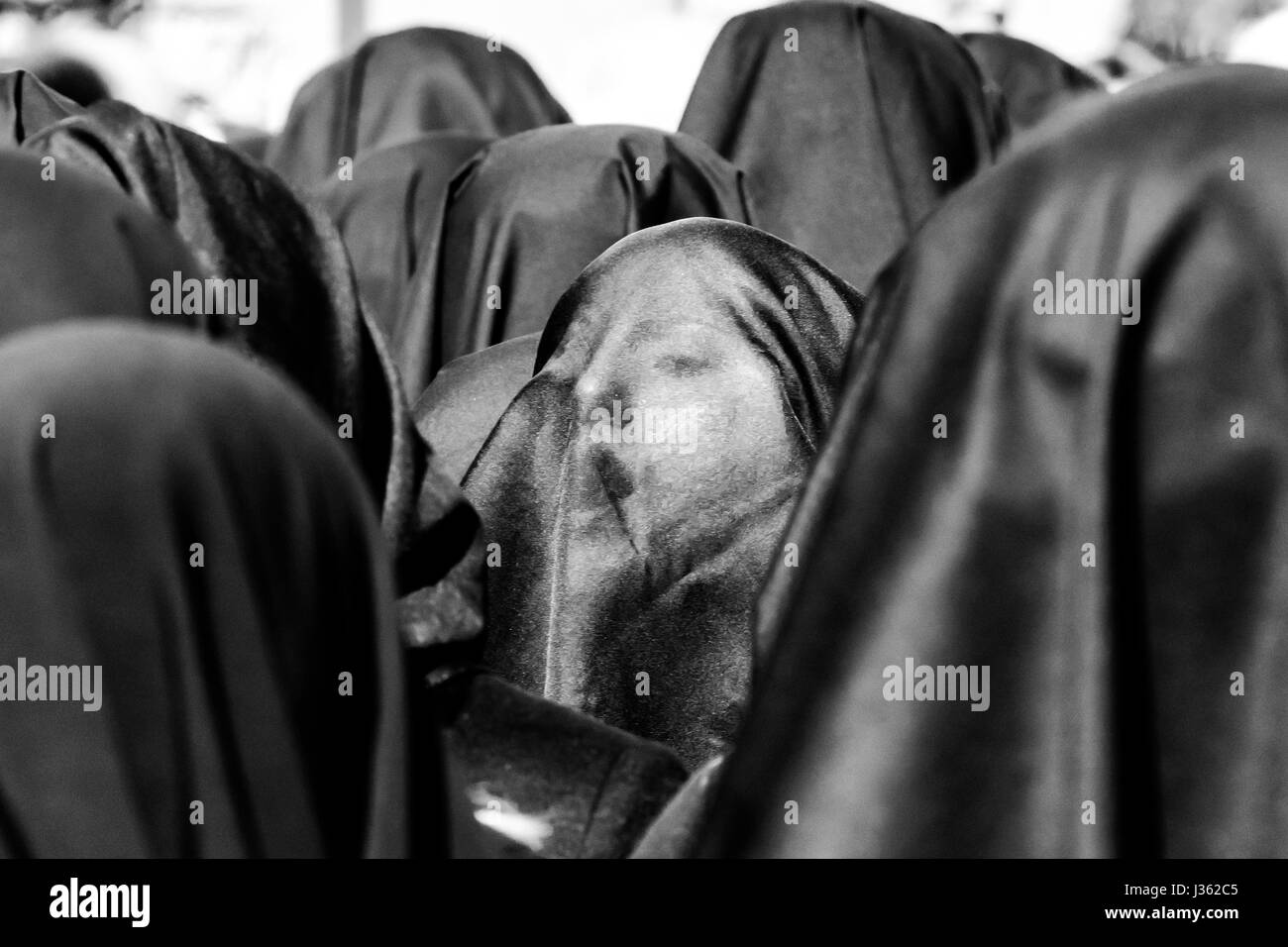 A transparent black veil lets appear the face of a woman among the ...