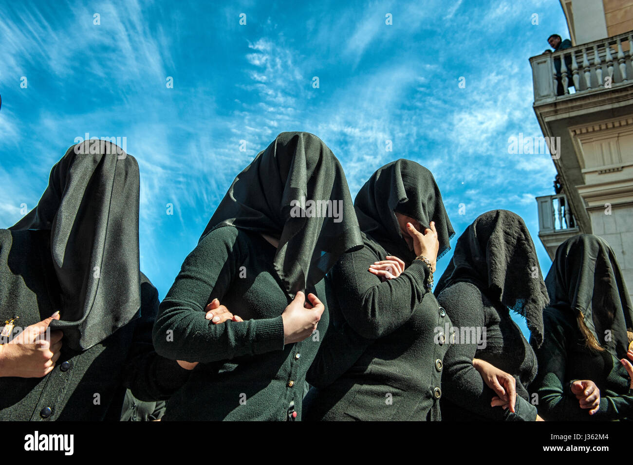 Women in black with the face covered by a black veil parade singing ...