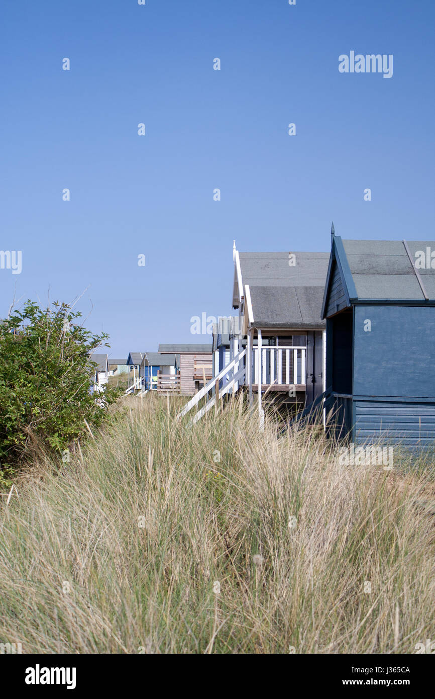 UK Norfolk coastline, beach huts sitting among the stand dunes at Old ...