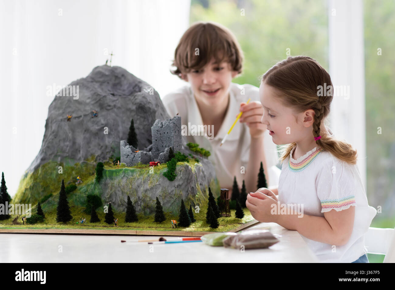 Children work on model building school project. Kids build miniature ...