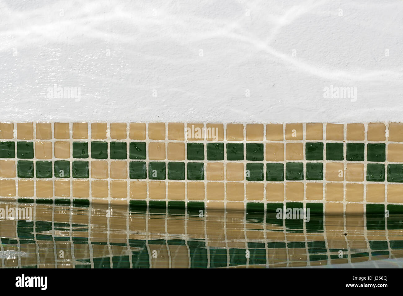 Detail view of water reflex in tiles and white wall of a swimming pool ...