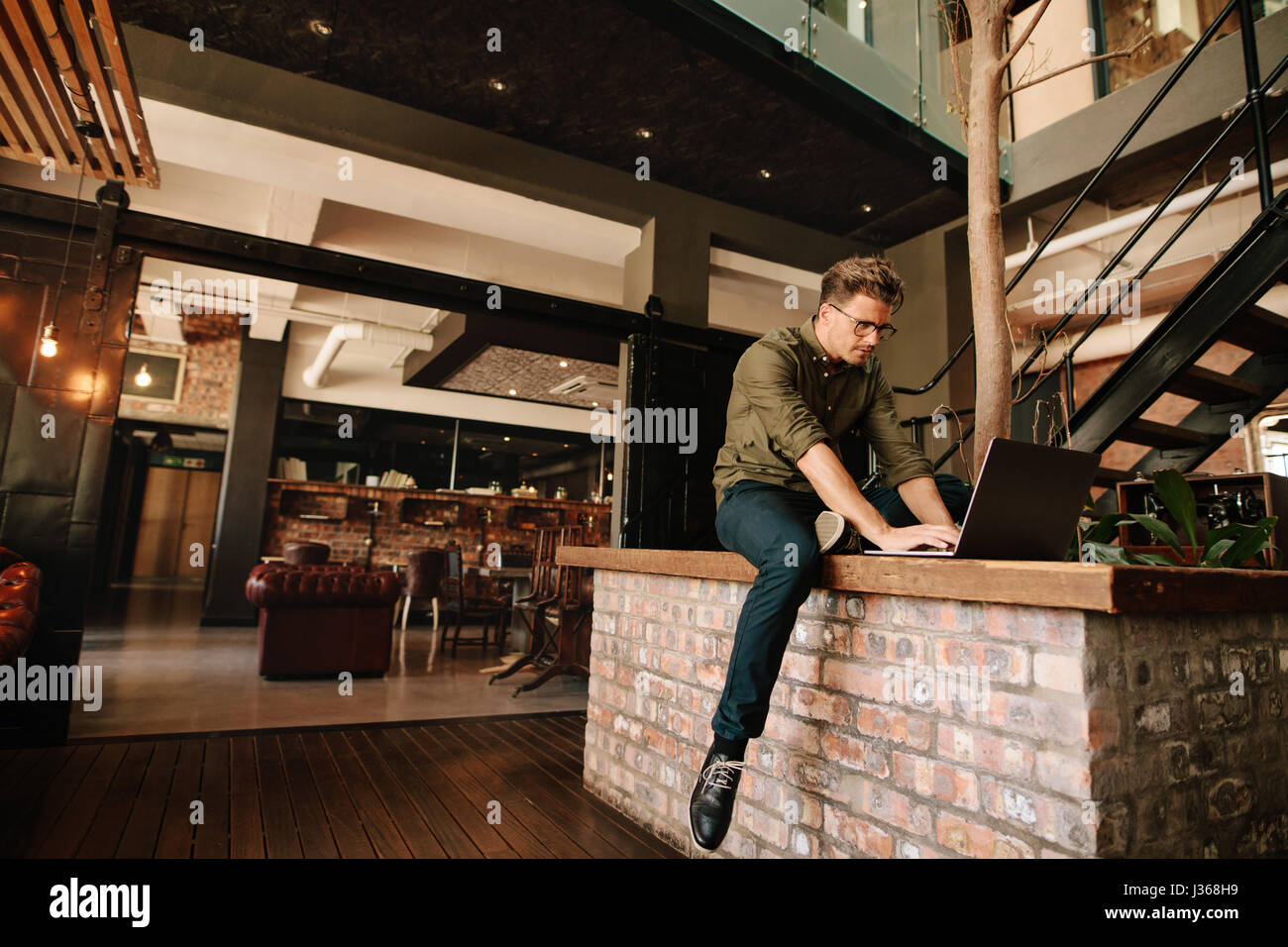 Shot of creative professional working on laptop. Young man in office ...