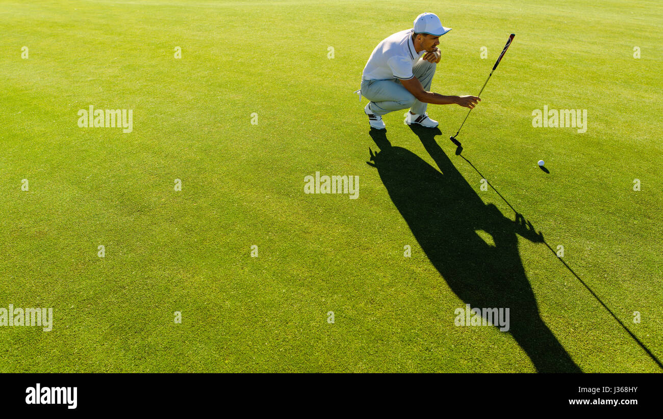 Professional golfer check line for putting golf ball on green grass ...