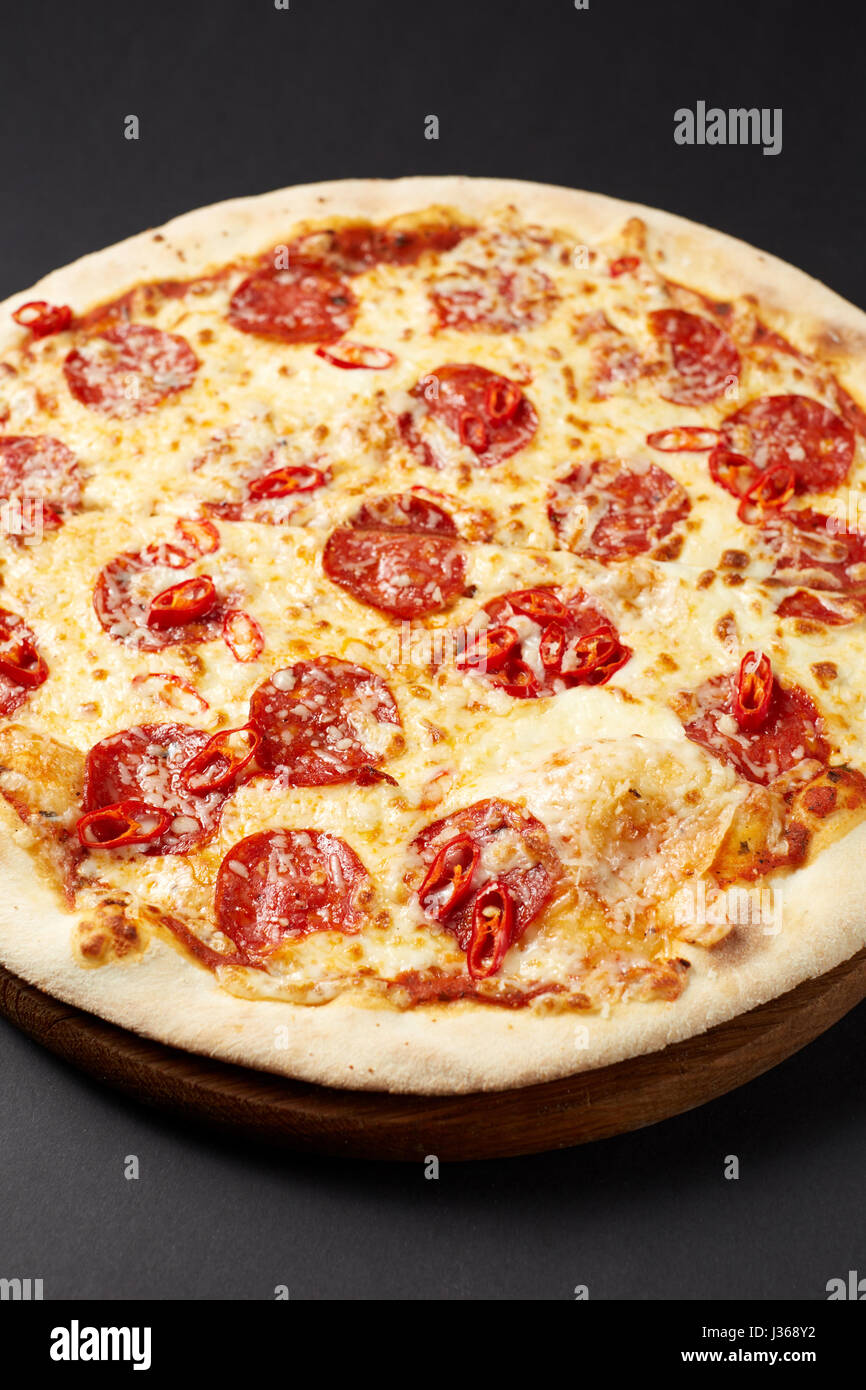 Hot pizza Diablo on a rustic wooden table. Italian food Stock Photo - Alamy