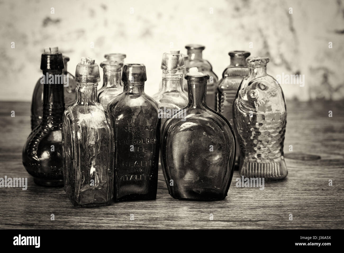 Selection of coloured glass bottles on a rustic background Stock Photo ...