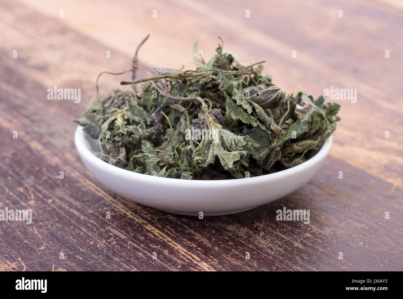 Porcelain bowl with dried nettle leaves Stock Photo - Alamy