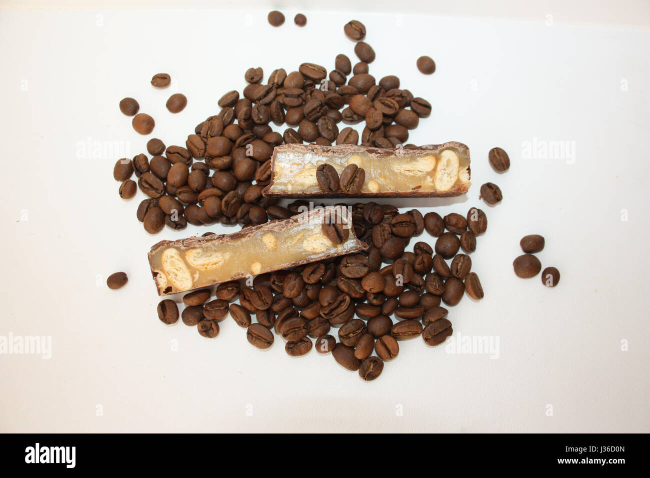Sweet candy in coffee beans on a white background Stock Photo - Alamy