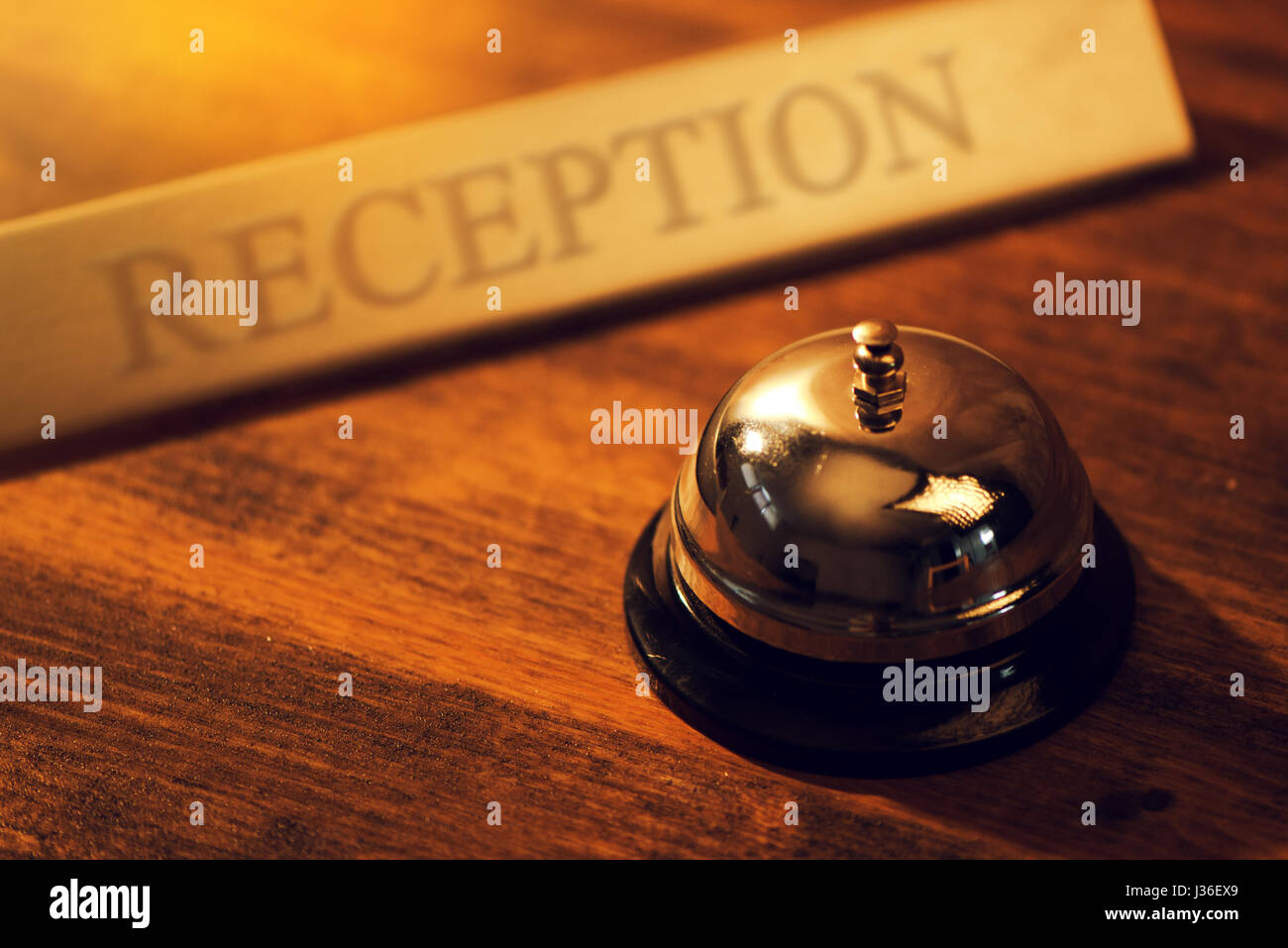Reception bell at hotel check in desk, warm retro tone, selective focus ...