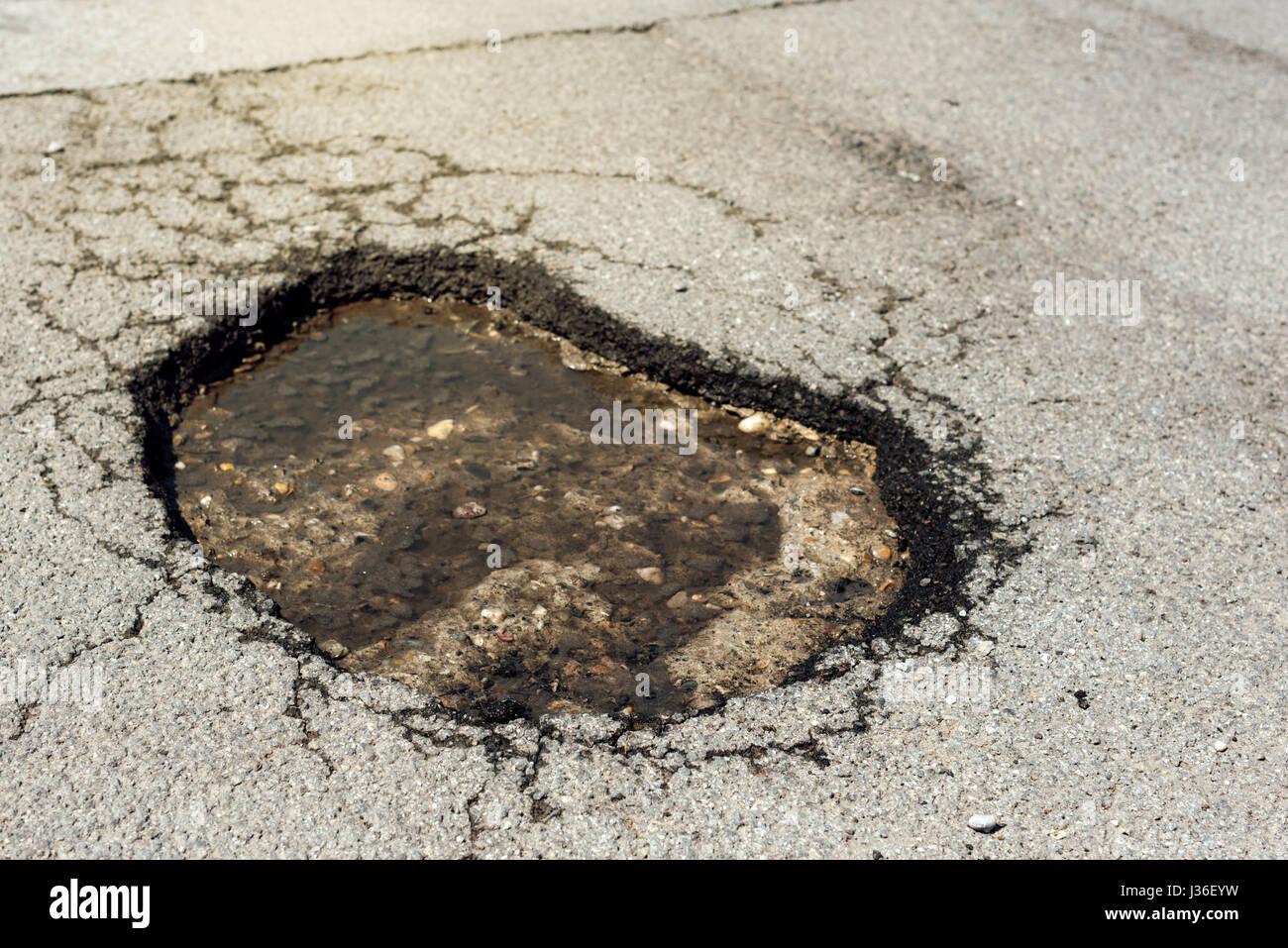Asphalt road hole damage, close up of damaged driveway Stock Photo - Alamy