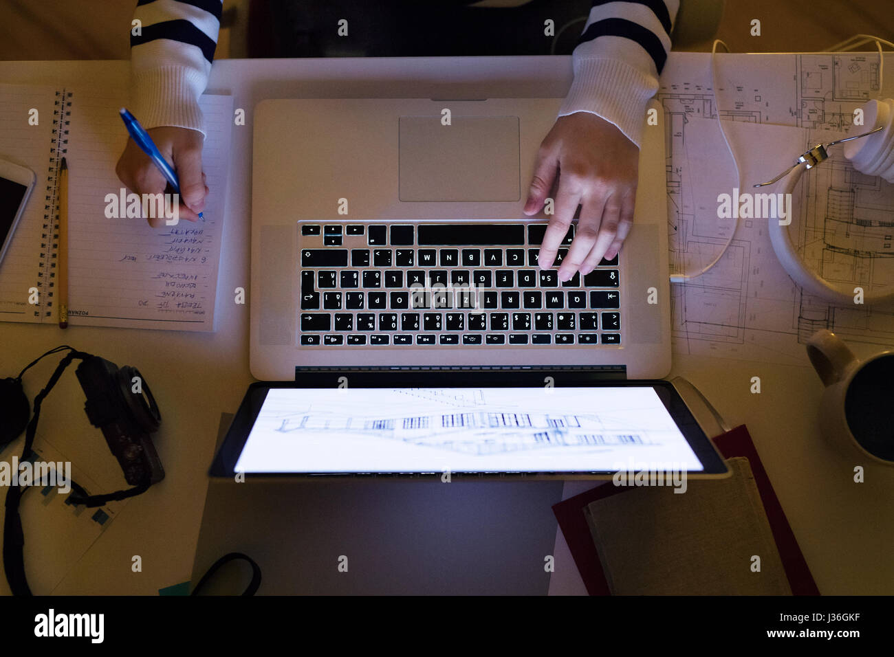 Unrecognizable woman sitting at desk working on laptop Stock Photo - Alamy