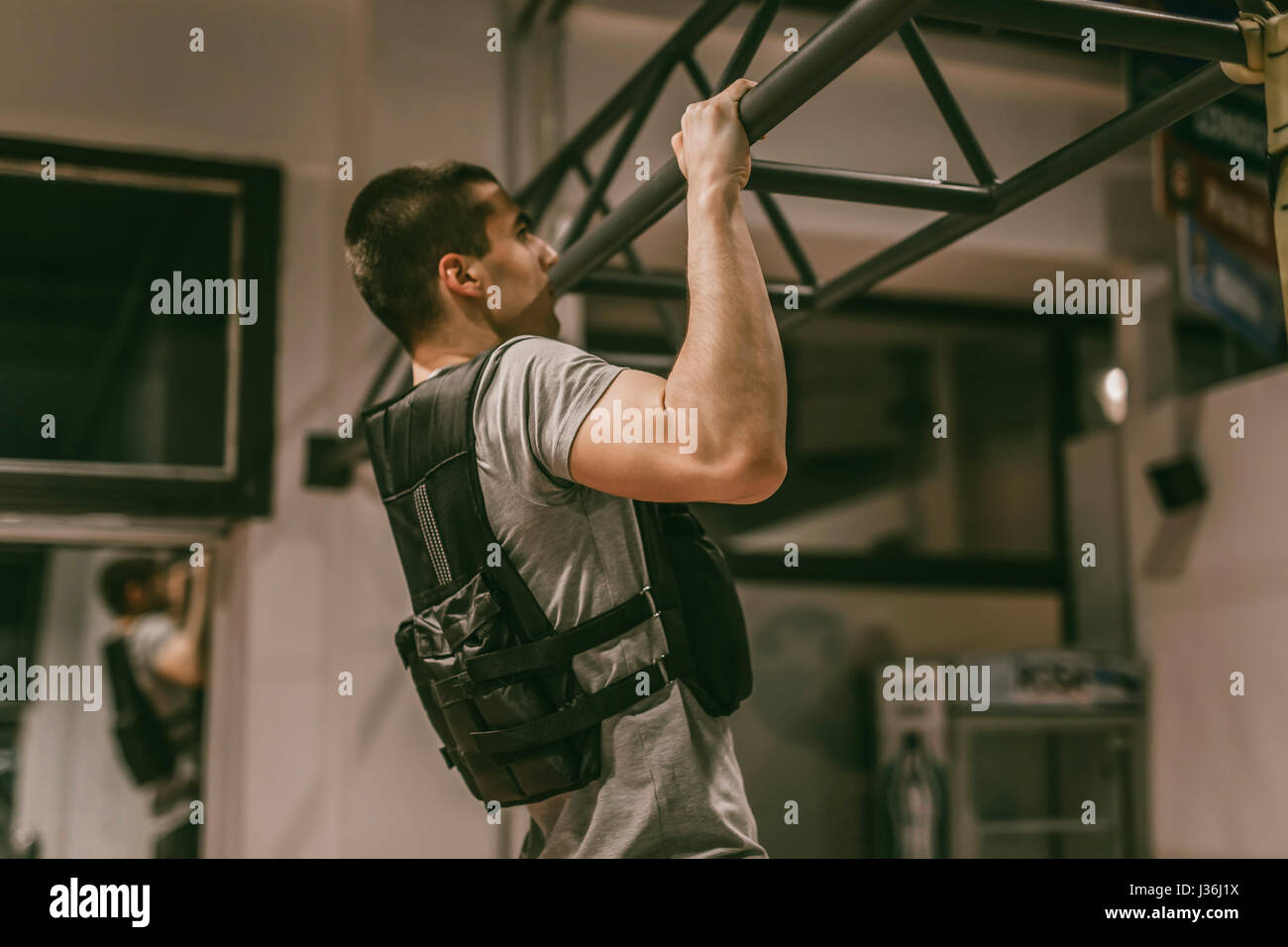 Strong young man doing pull ups in the gym Stock Photo - Alamy