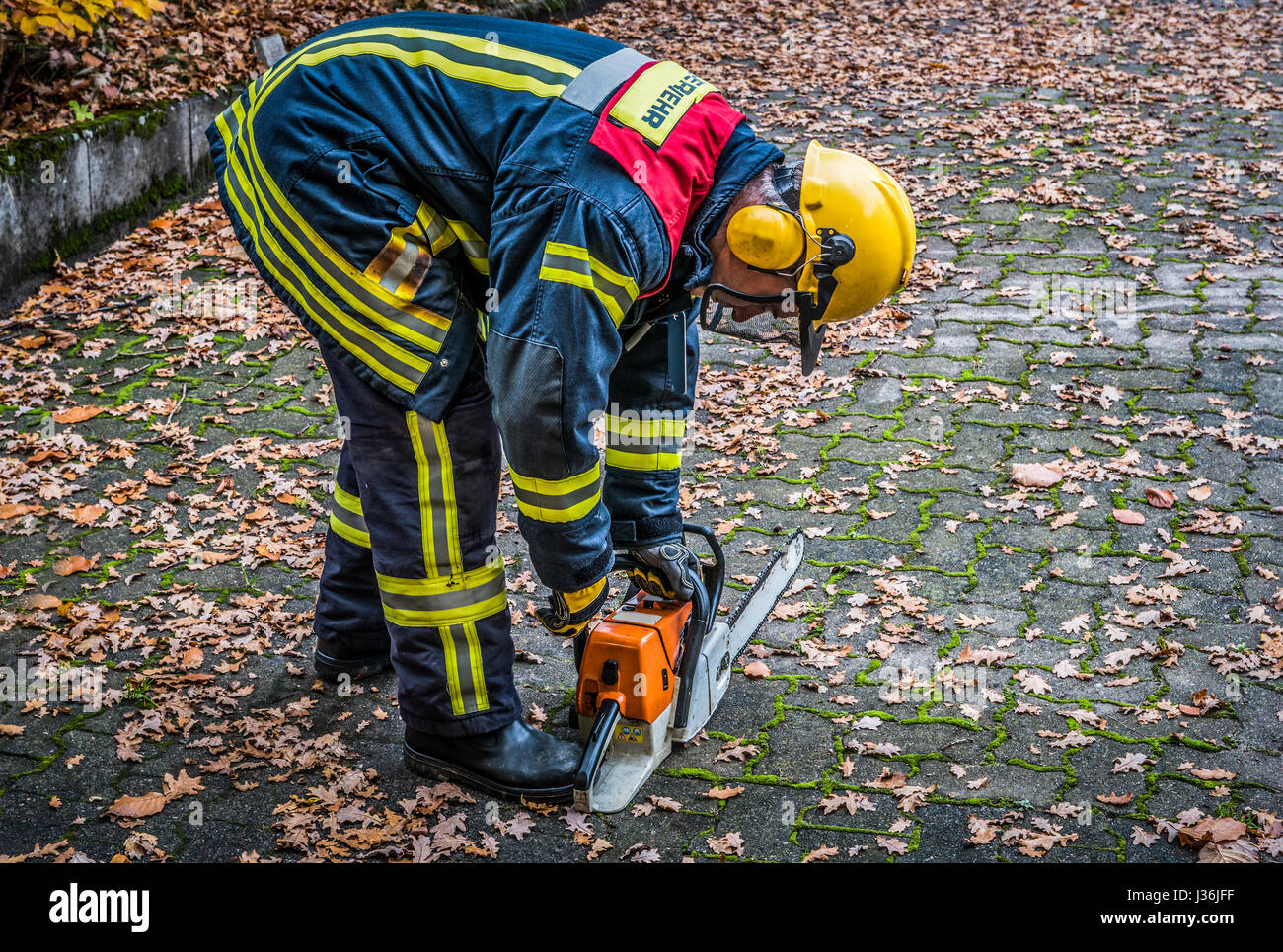 Firefighter in action with a chain saw - HDR Stock Photo - Alamy