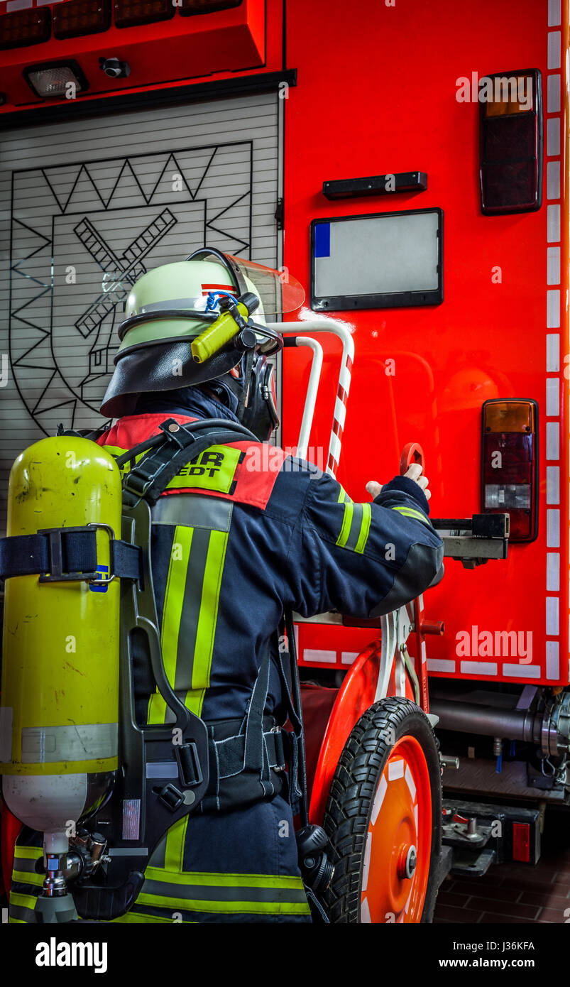 Firefighter in action on the emergency vehicle with oxygen bottle and ...