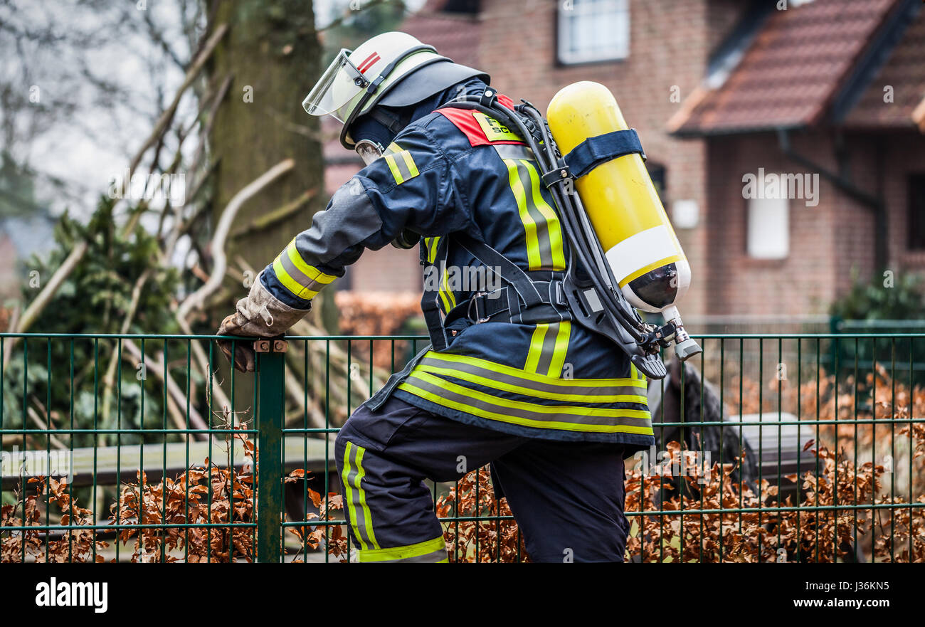 Firefighter in action outdoor with oxygen mask and oxygen cylinder ...