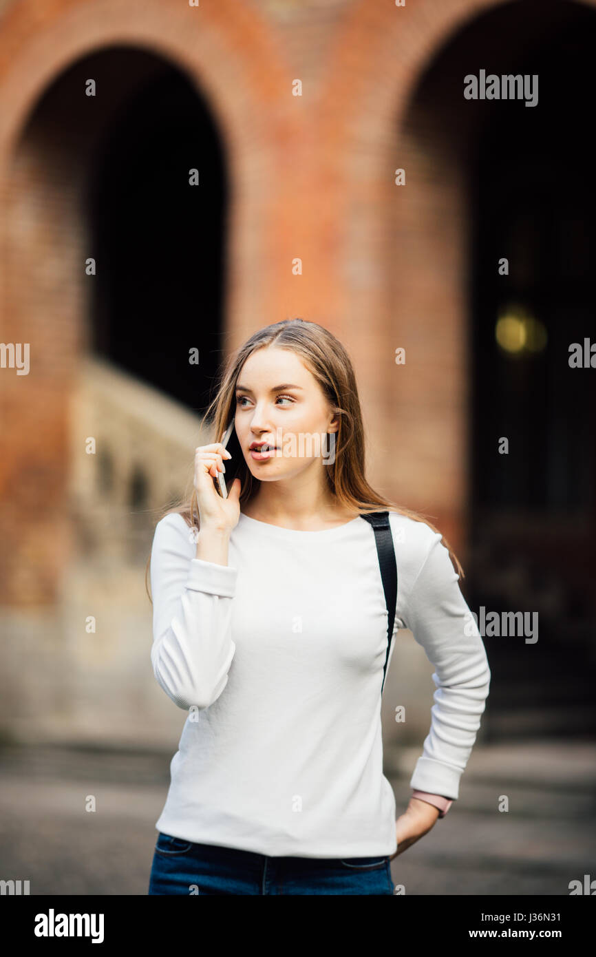 Happy student girl walking and calling on mobile phone outdoors Stock ...