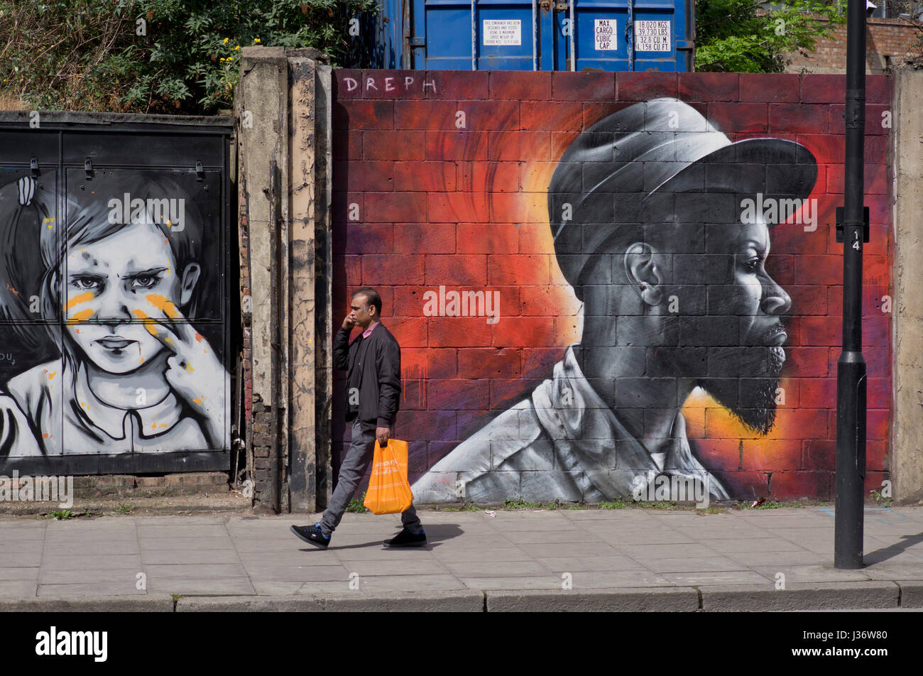 Man walks past graffiti art mural in the streets of Hoxton. London.UK ...