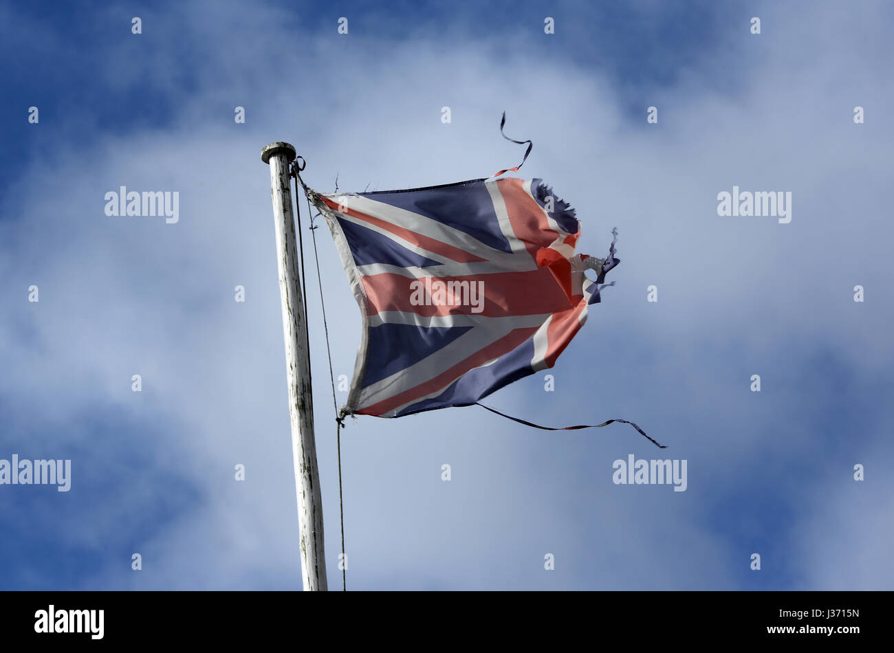 A tattered Union Flag blowing in the wind pictured against a cloudy ...