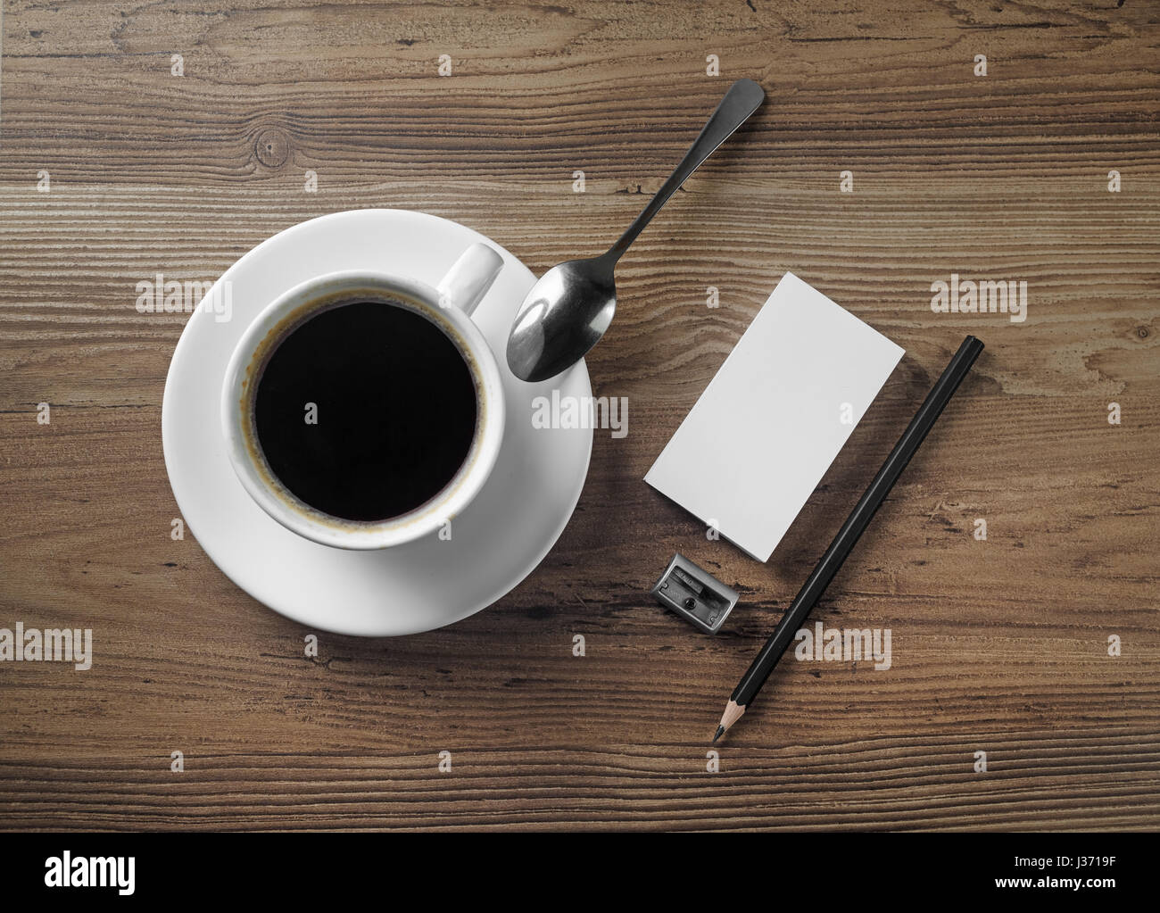 Coffee cup, bank business cards, pencil and eraser on wood table ...