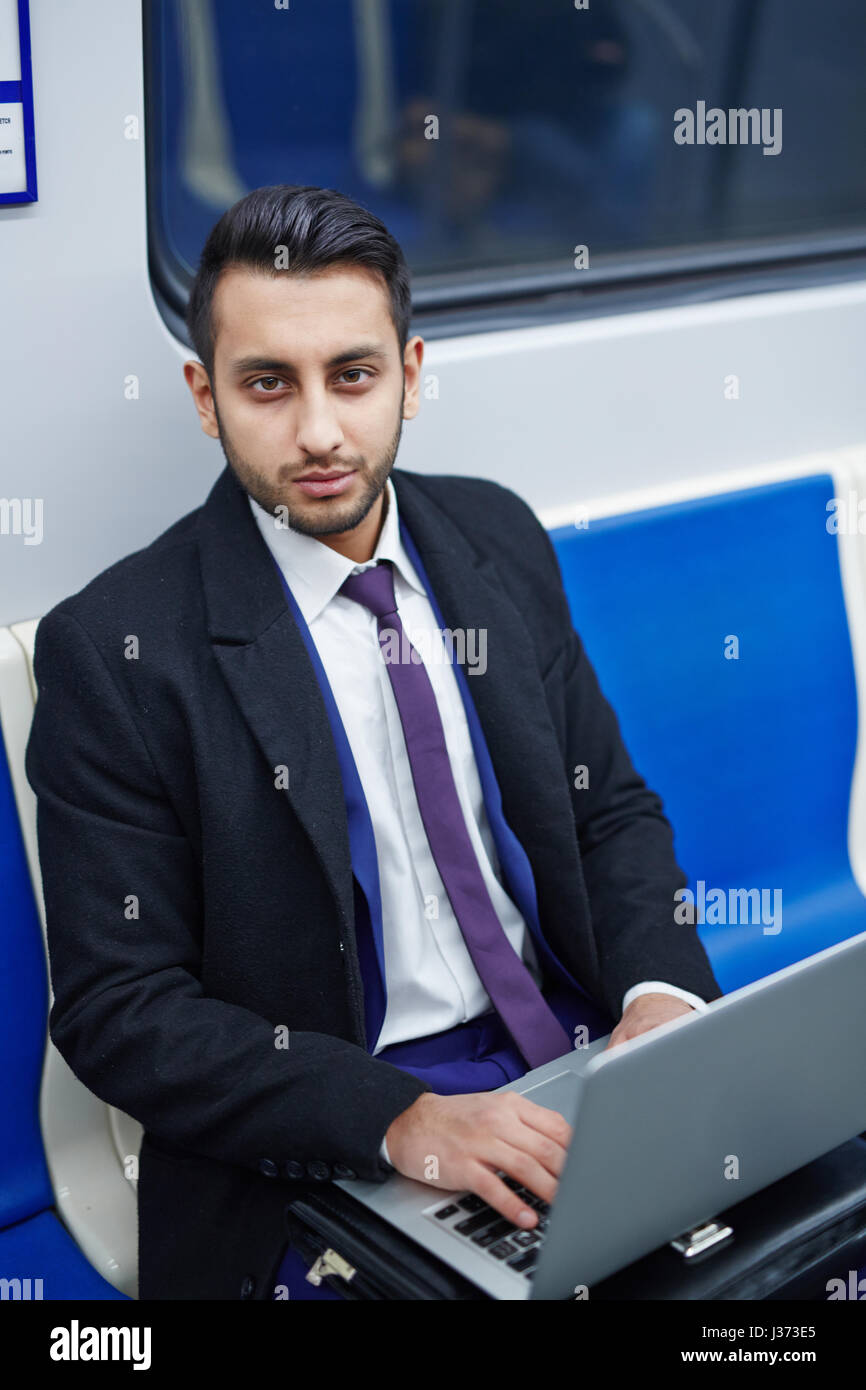 Middle-Eastern Businessman Using Laptop in Subway Stock Photo - Alamy