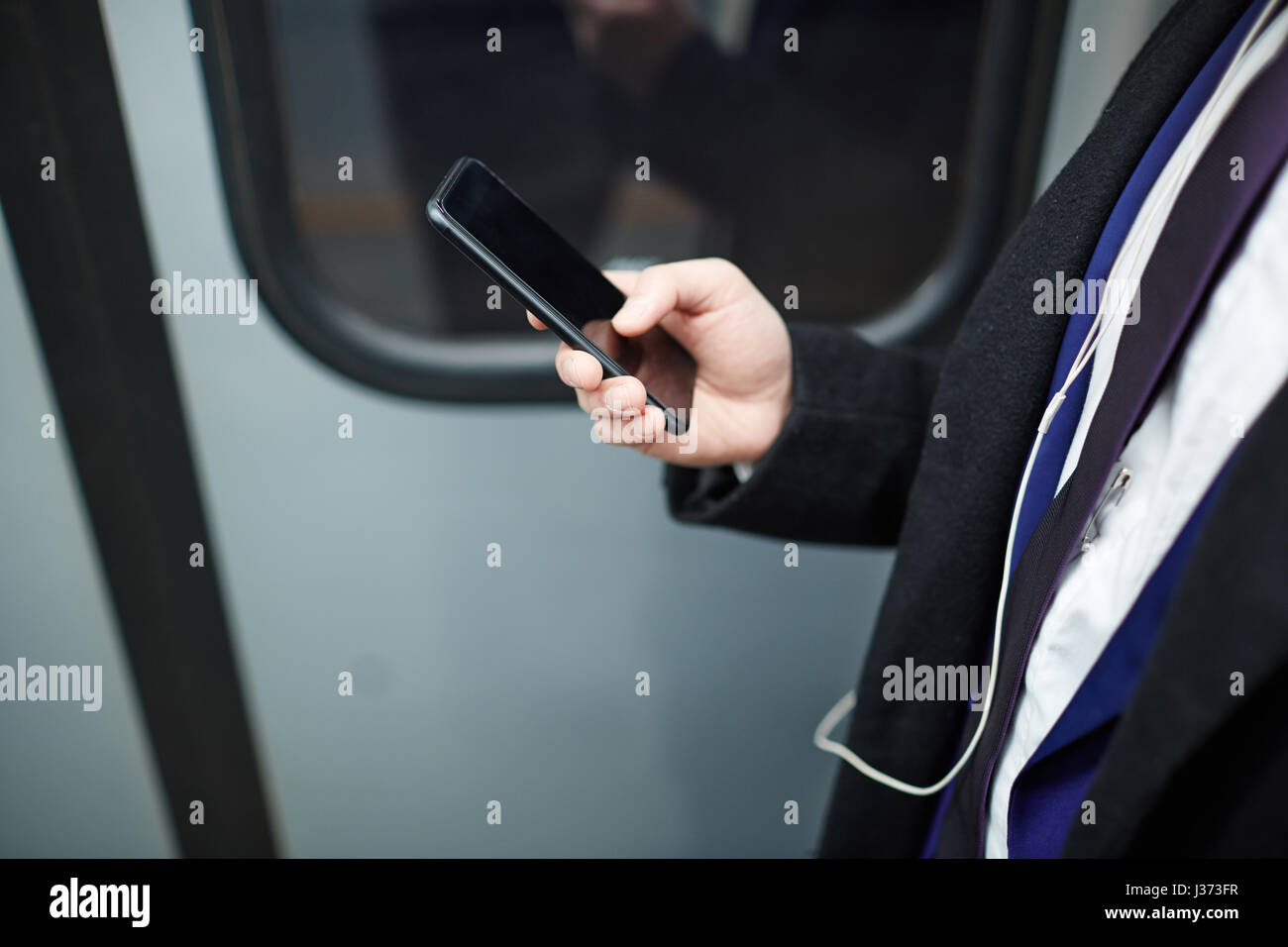 Businessman Holding Smartphone in Subway Stock Photo - Alamy