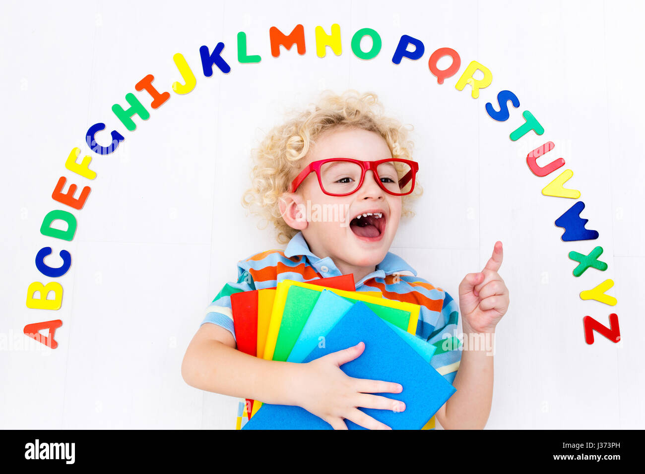 Happy preschool child learning to read and write playing with colorful ...