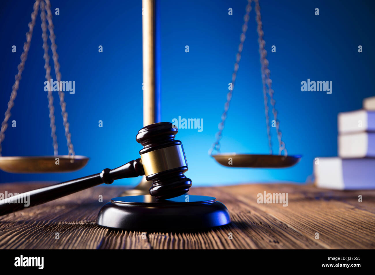 Scale of justice on old wooden table and blue background. Law theme and ...