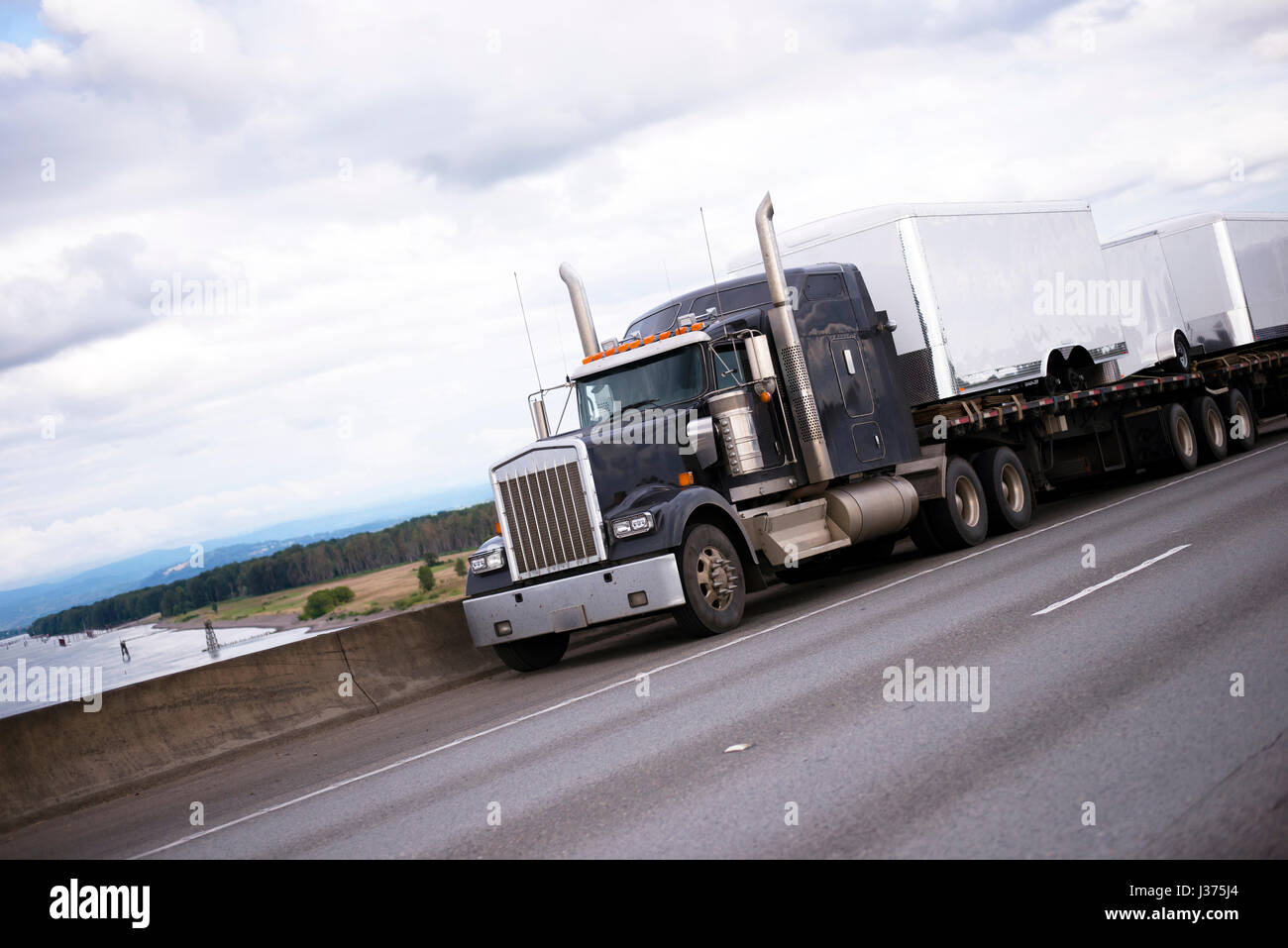 Classic American bonneted large black rig semi truck with high stylish ...
