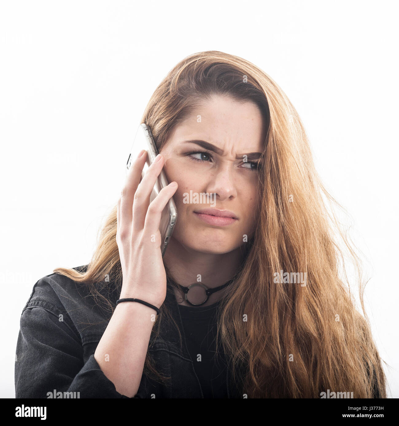 A pretty 15 year old girl speaking on smartphone looking annoyed in the ...