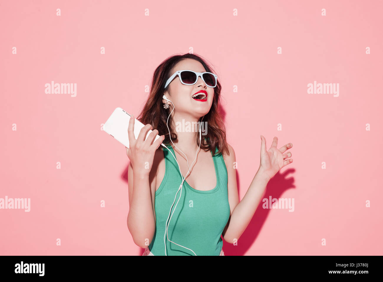 Young attractive asian woman with professional makeup singing and ...