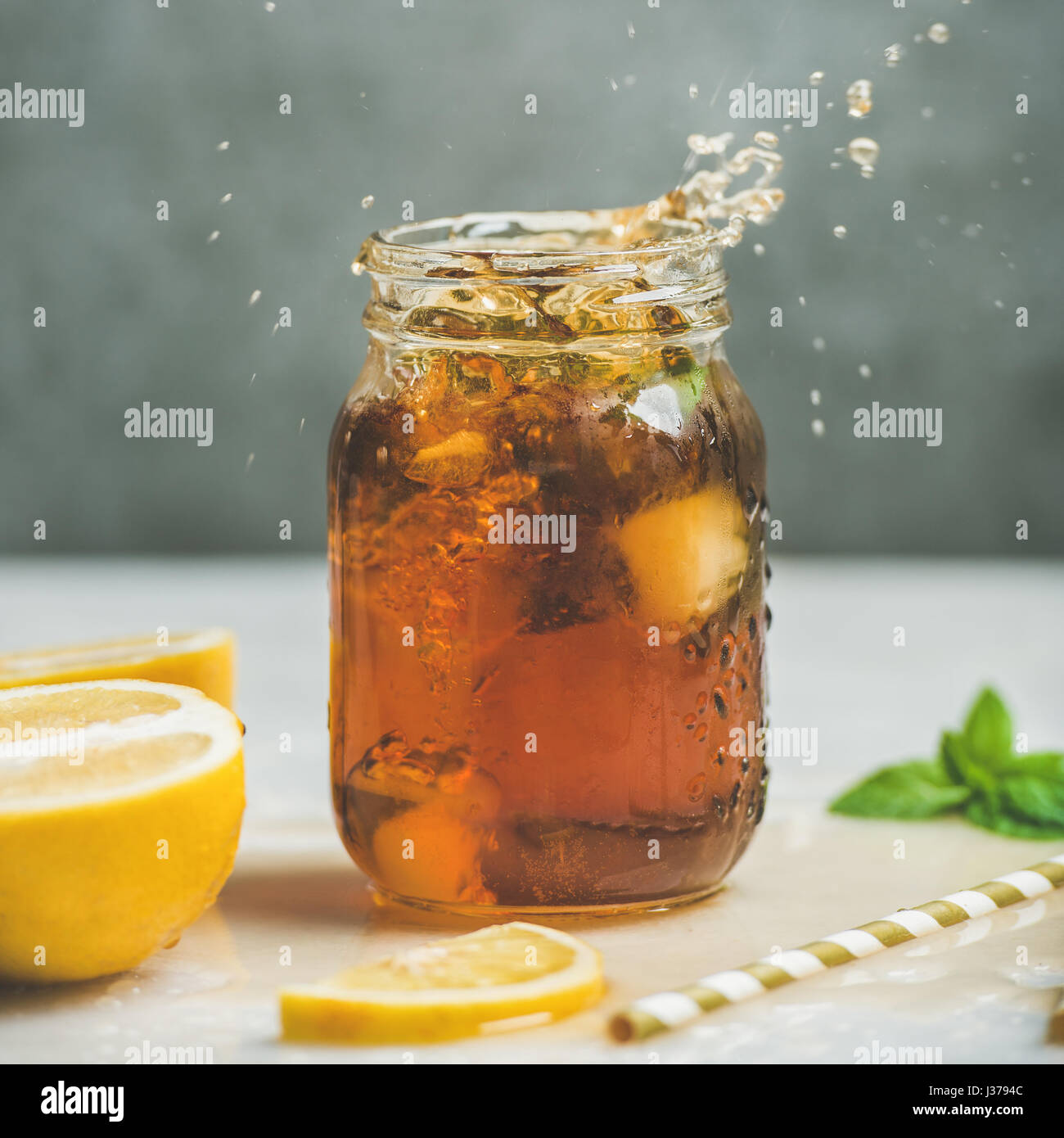 Iced tea with fresh herbs in jar with splashes Stock Photo - Alamy